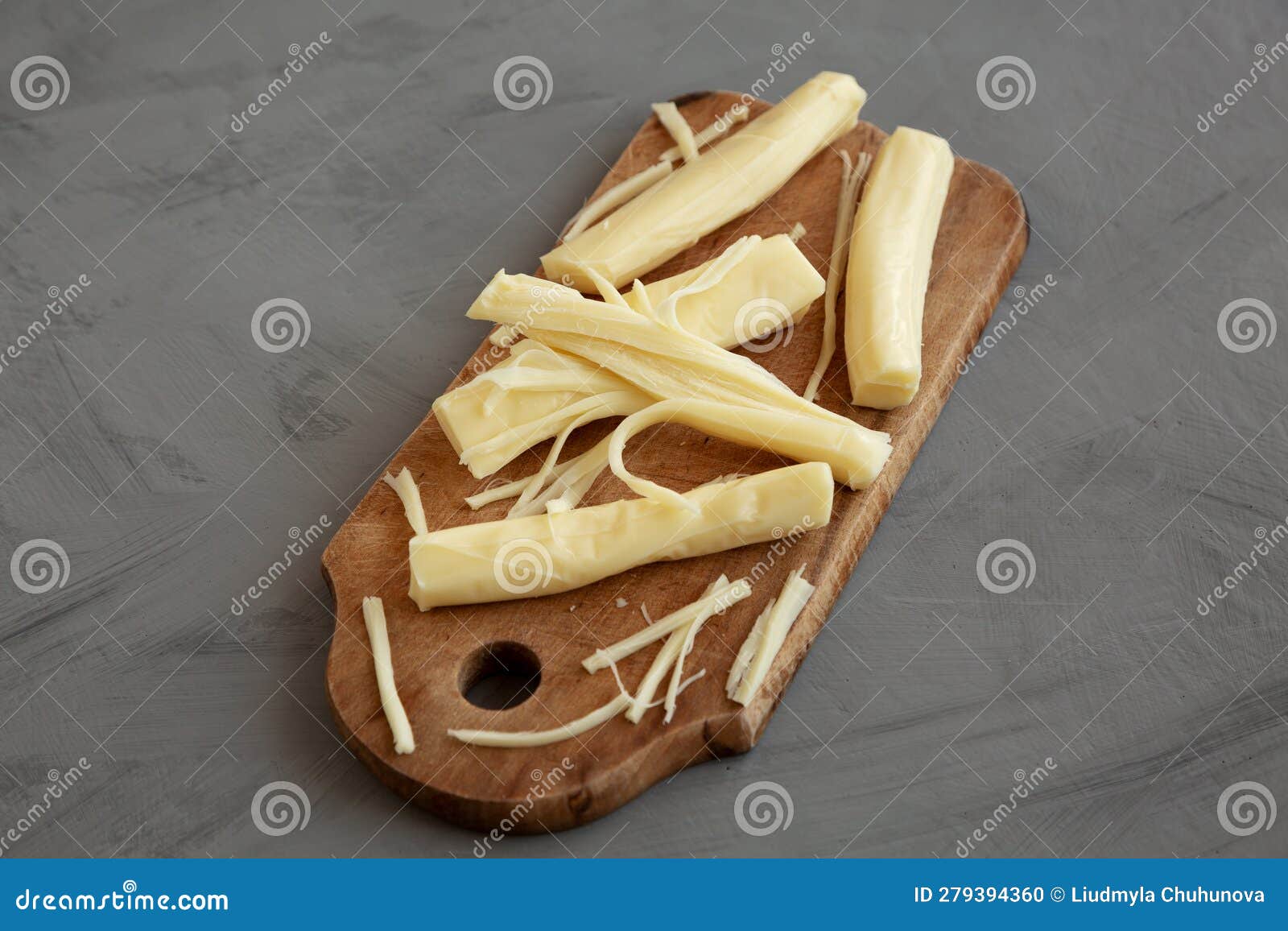 Organic String Cheese on a Rustic Wooden Board on a Gray Background ...