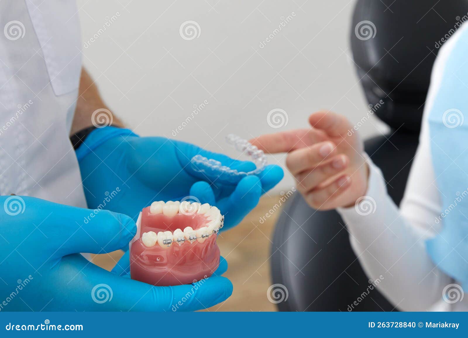 Orthodontist Showing Model of Human Jaw with Wire Braces and Aligners ...