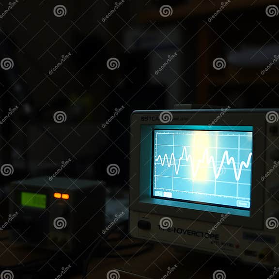 An Oscilloscope Measuring the Signal from a Power Source with a Focus on the Screen Displaying a ...