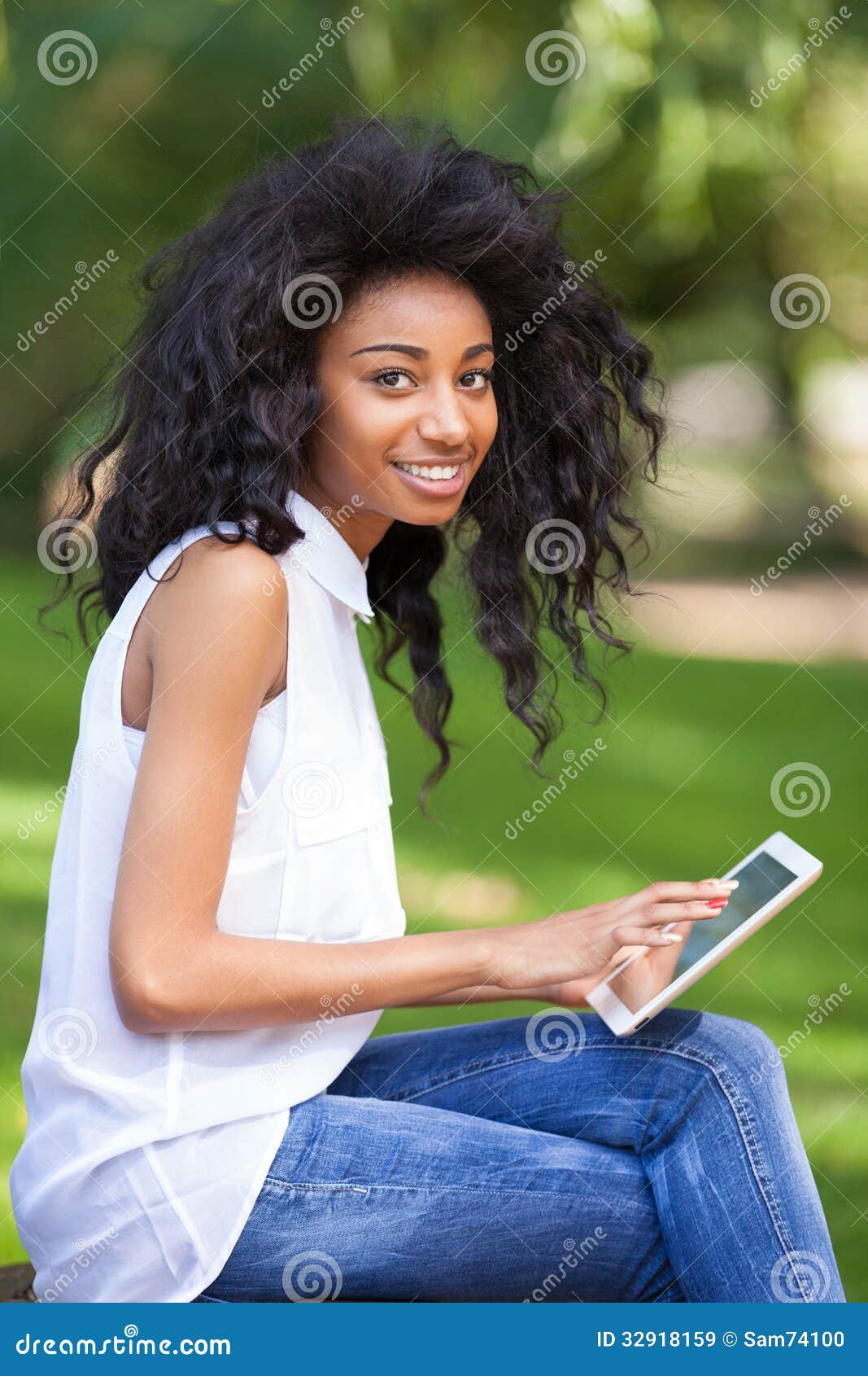 Outdoor Portrait Of A Teenage Black Girl Using A Tactile Tablet Stock