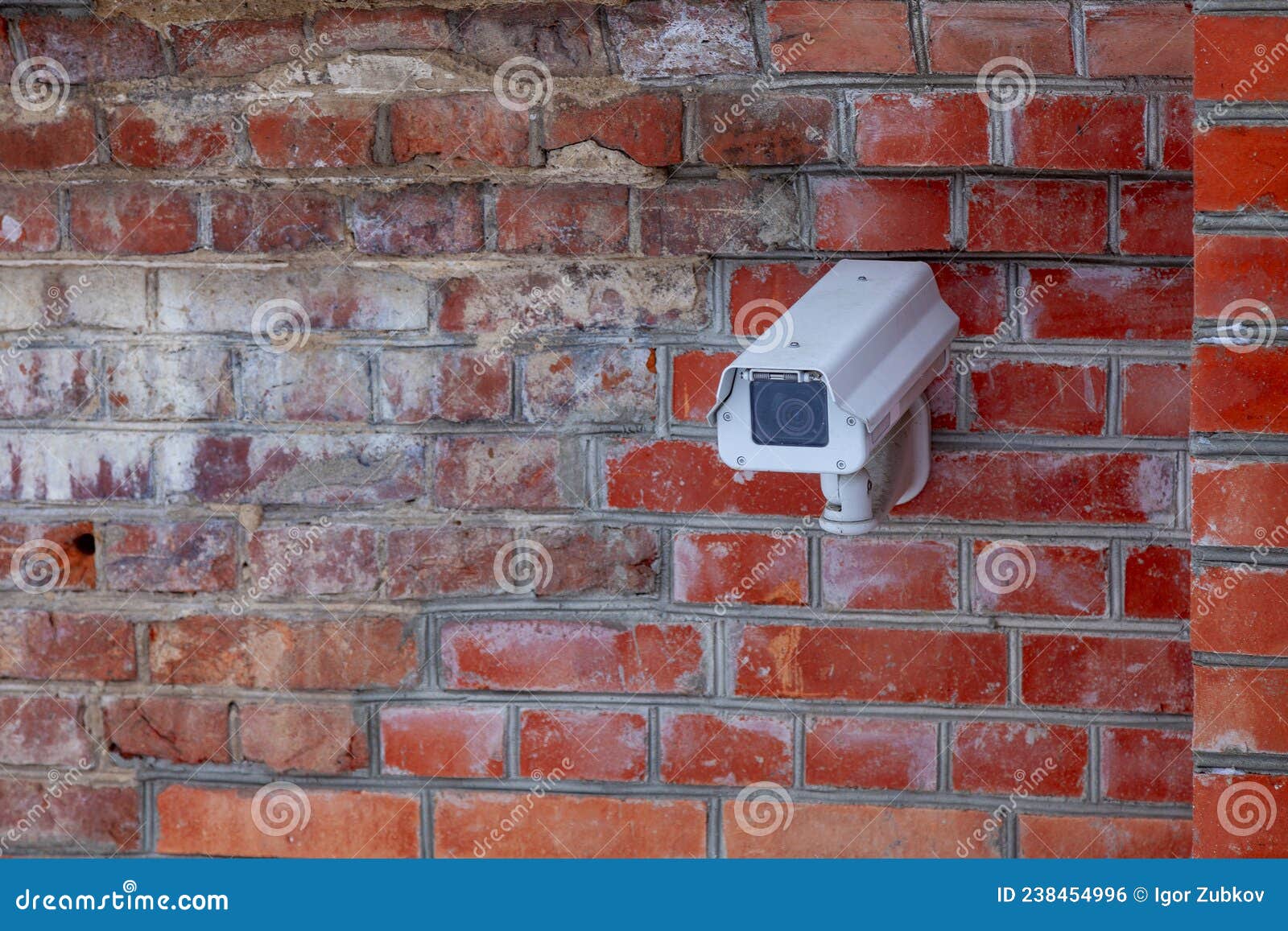 An Outdoor Surveillance Camera is Attached To the Brick Wall of the ...