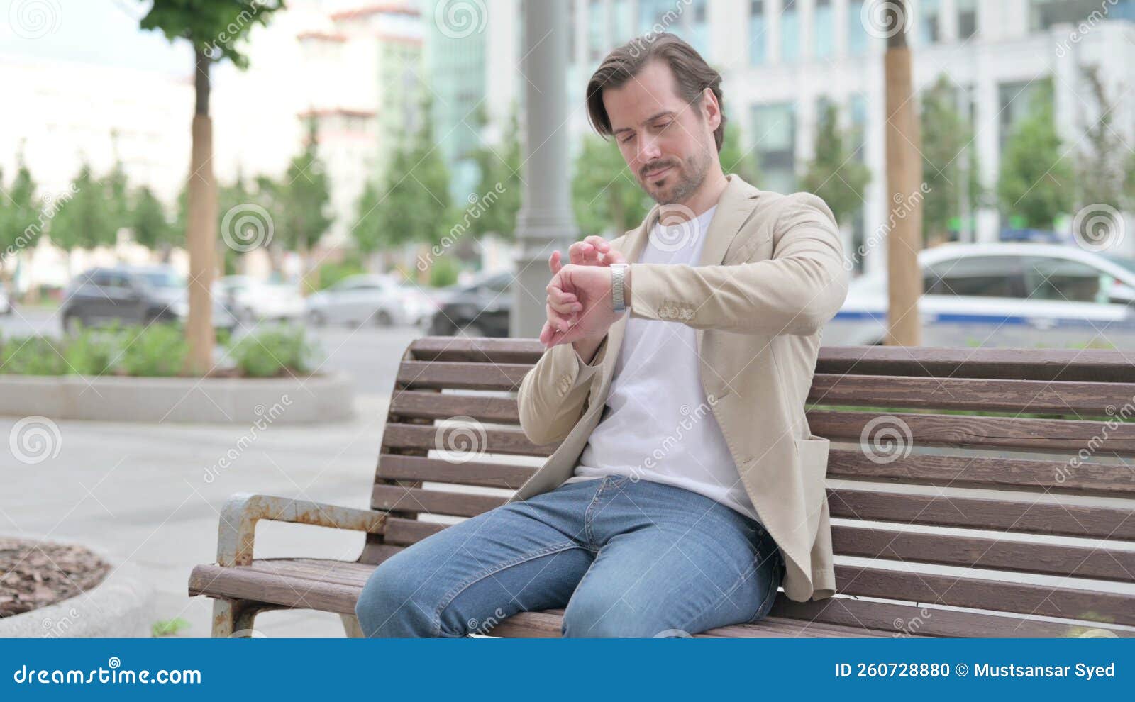 Outdoor Young Man Using Smartwatch while Sitting on Bench Stock Photo ...