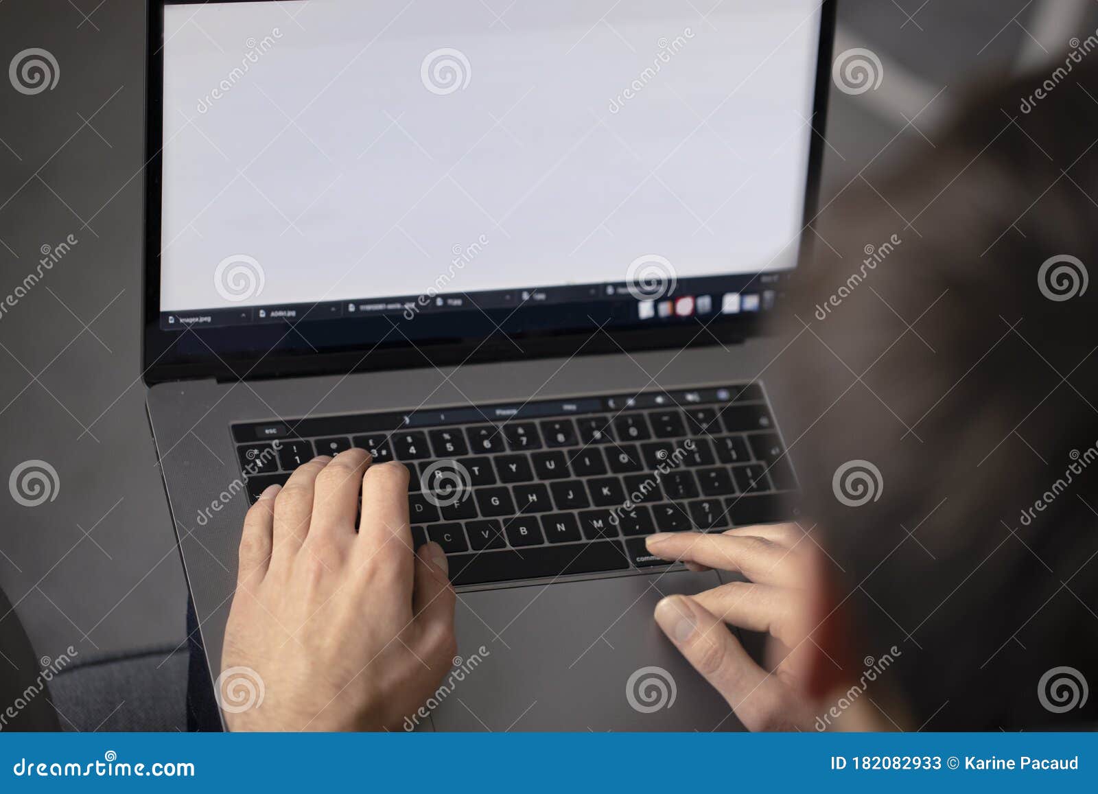 Over the Shoulder of a Man Typing on a Laptop with a Blank White Screen ...