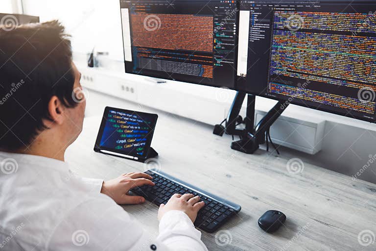 Over the Shoulder View it Guy Working on Two Screens Coding on Desktop ...