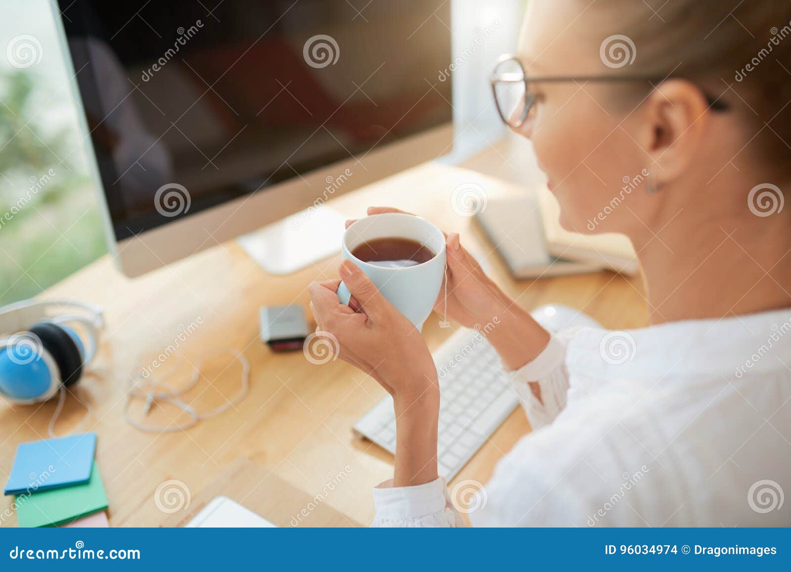 Drinking Tea at Work stock photo. Image of young, eyeglasses - 96034974