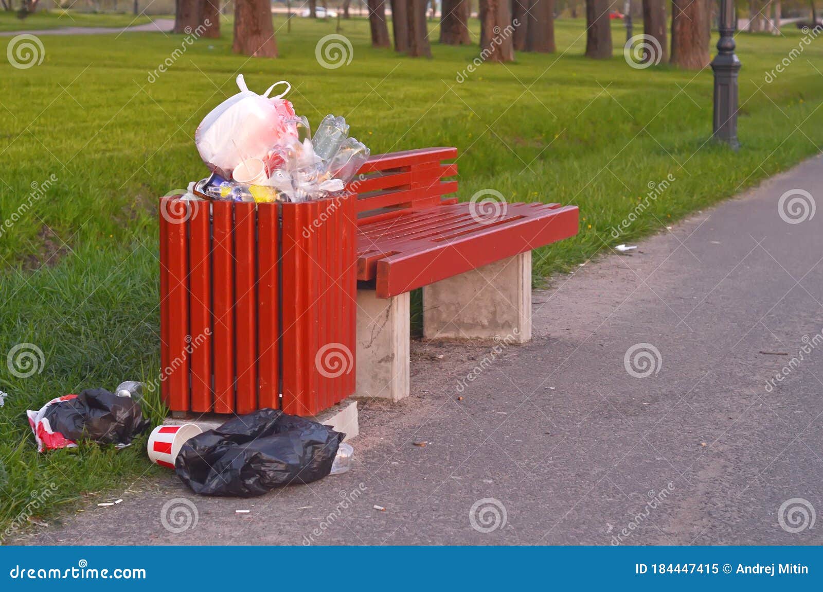 Overflowing Trash Can and Scattered Garbage Nearby in the Park on ... Overflowing Trash Can and Scattered Garbage Nearby in the Park on ...