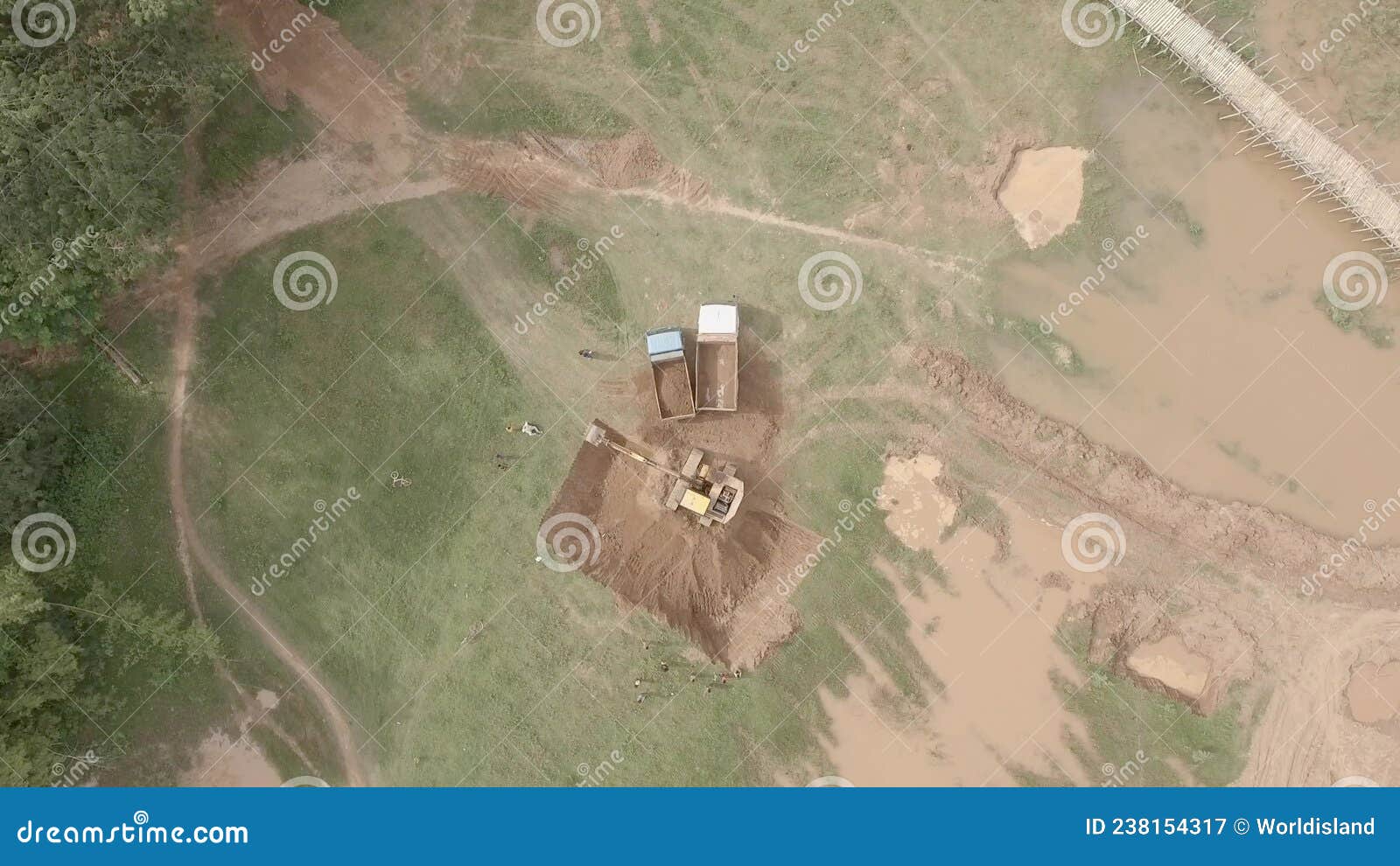 Overhead Drone Shot of an Excavator Loading Earth Inside Two Trucks ...