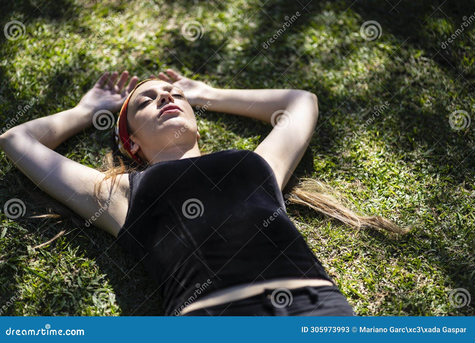 Overhead Portrait Of Blonde Woman Lying On The Grass With Lights And