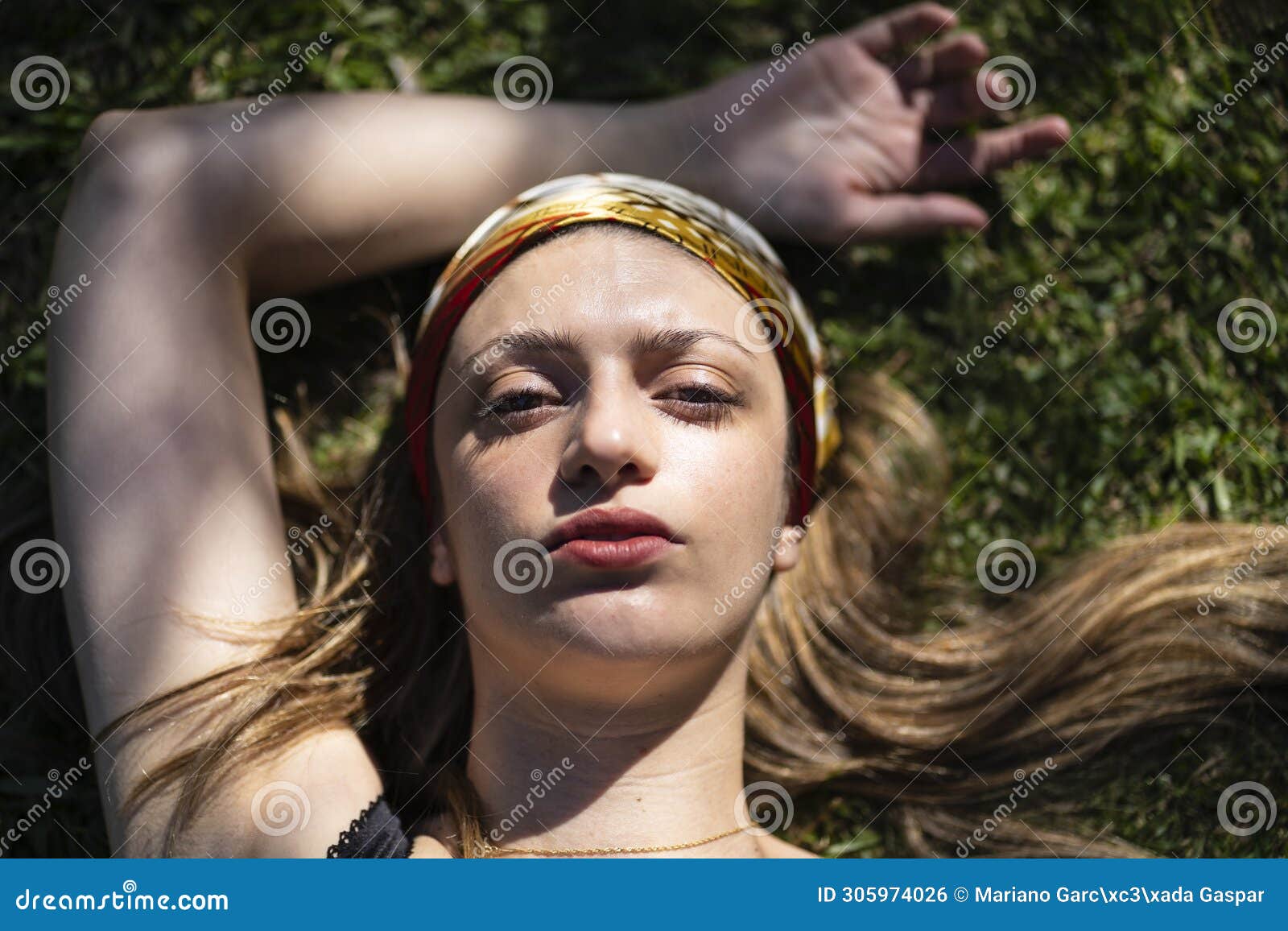 Overhead Portrait Of Blonde Woman Lying On The Grass With Lights And