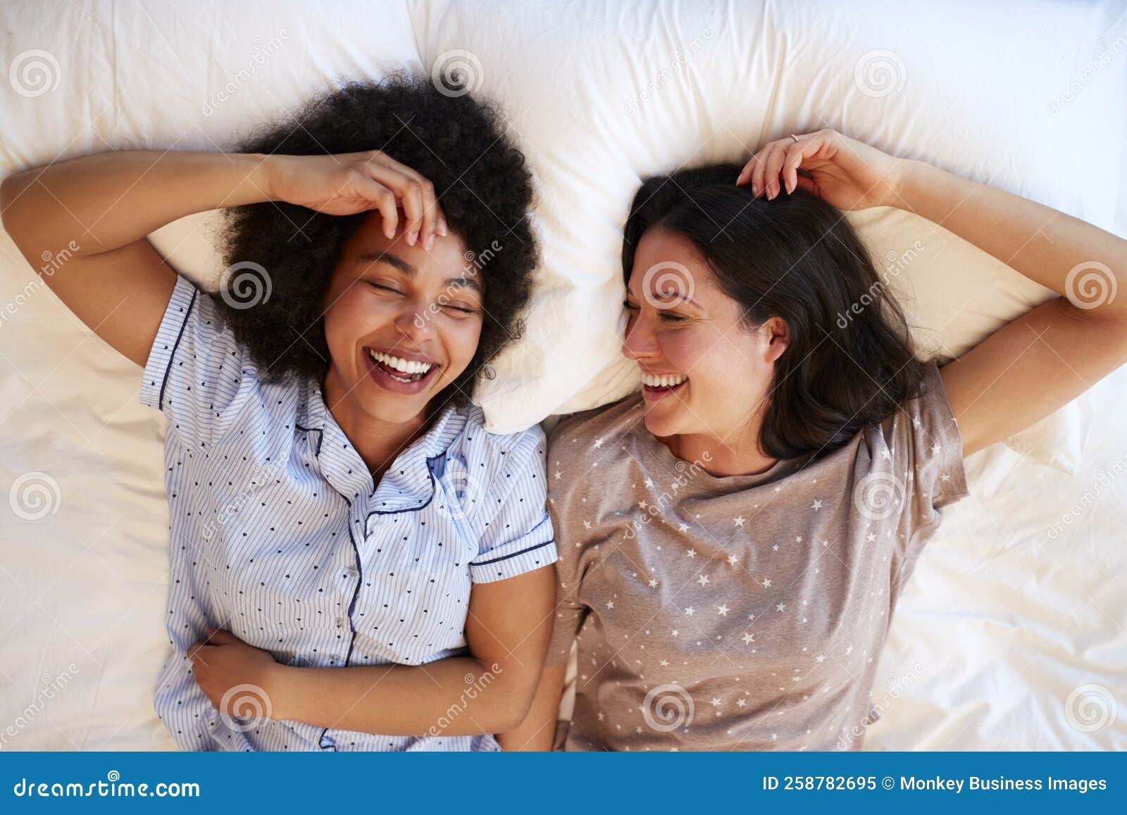 Overhead Portrait Of Loving Same Sex Female Couple Wearing Pyjamas