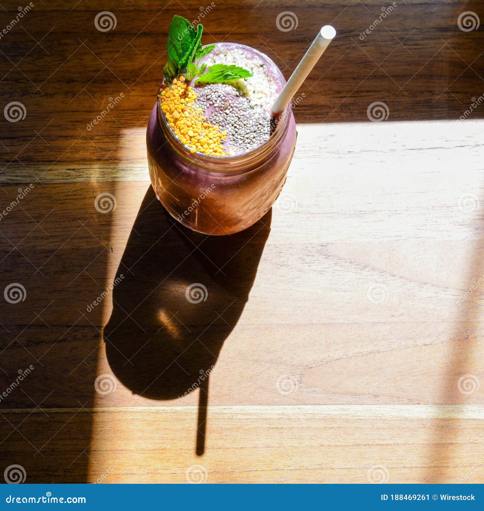 Overhead Shot of a Smoothie with a Straw on a Wooden Table Under the ...