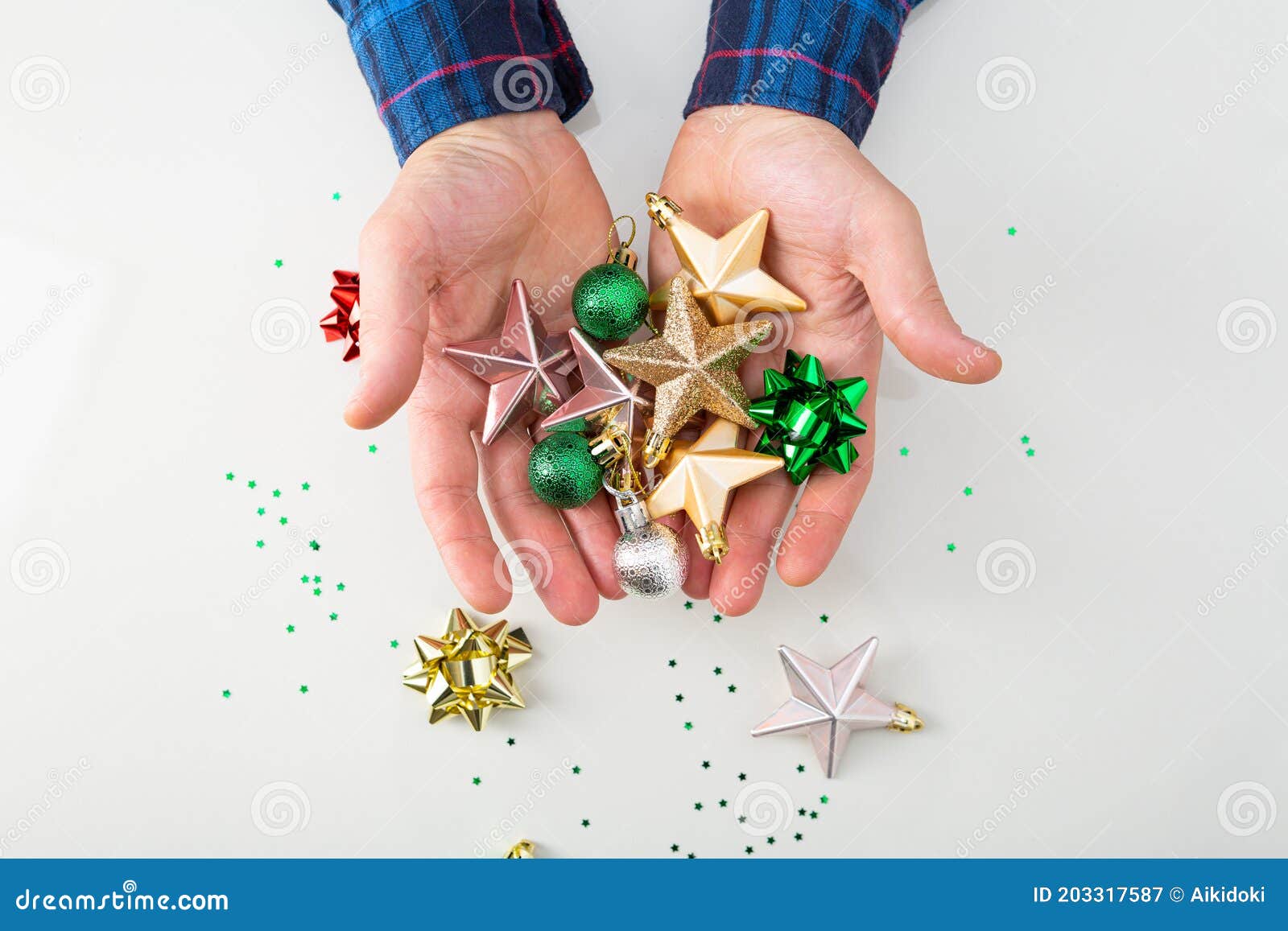 Overhead View of Christmas Stars and Baubles in Hands on Light Surface ...