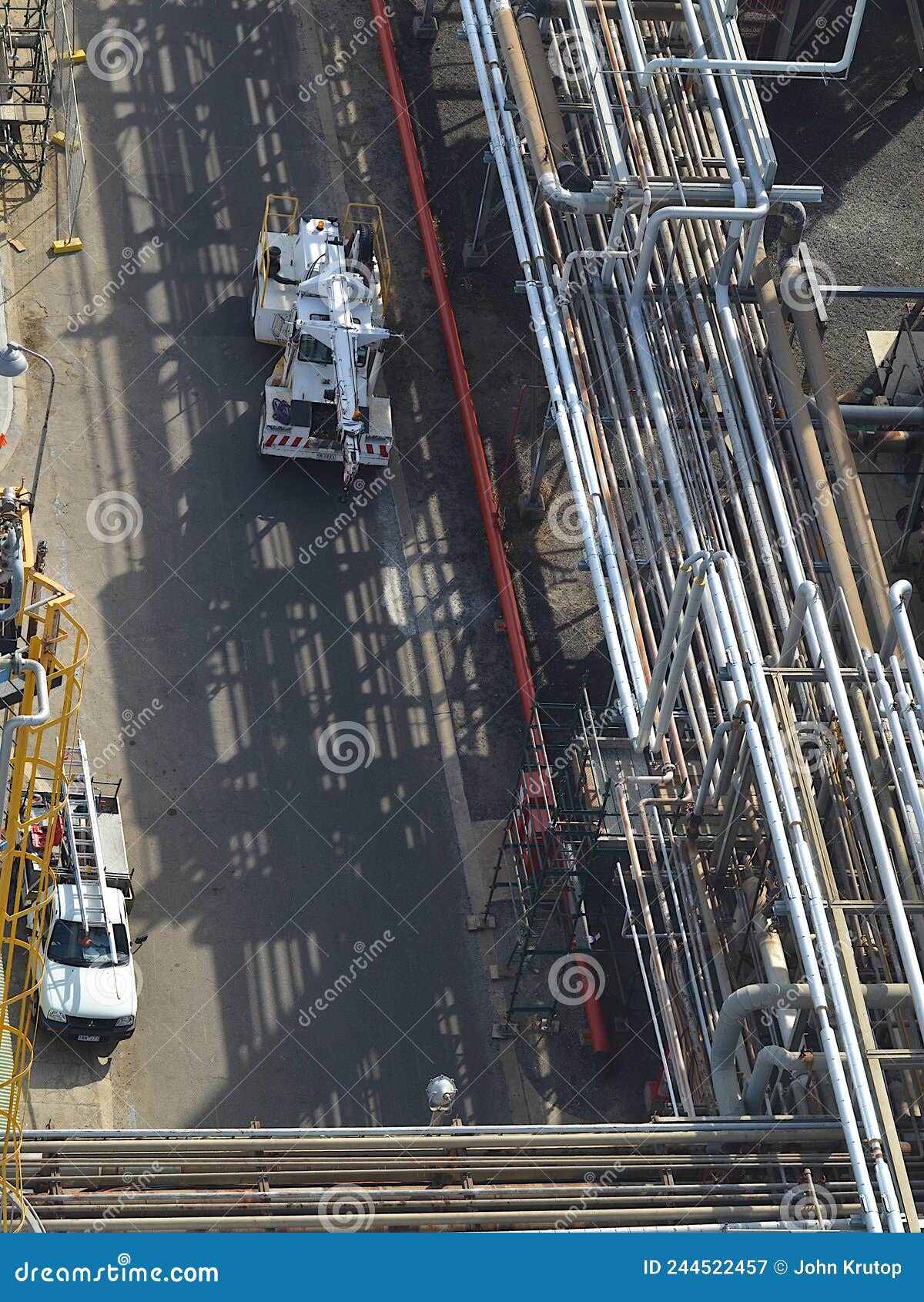 Overhead View of a Construction Worker Amongst Pipes and Scaffolding ...
