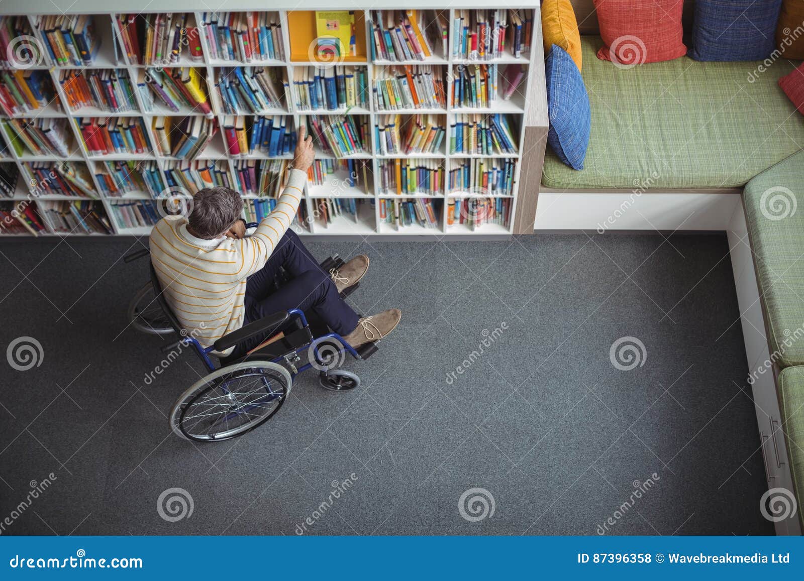 Overhead View of Disabled School Teacher Selecting Book in Library ... Overhead View of Disabled School Teacher Selecting Book in Library ...