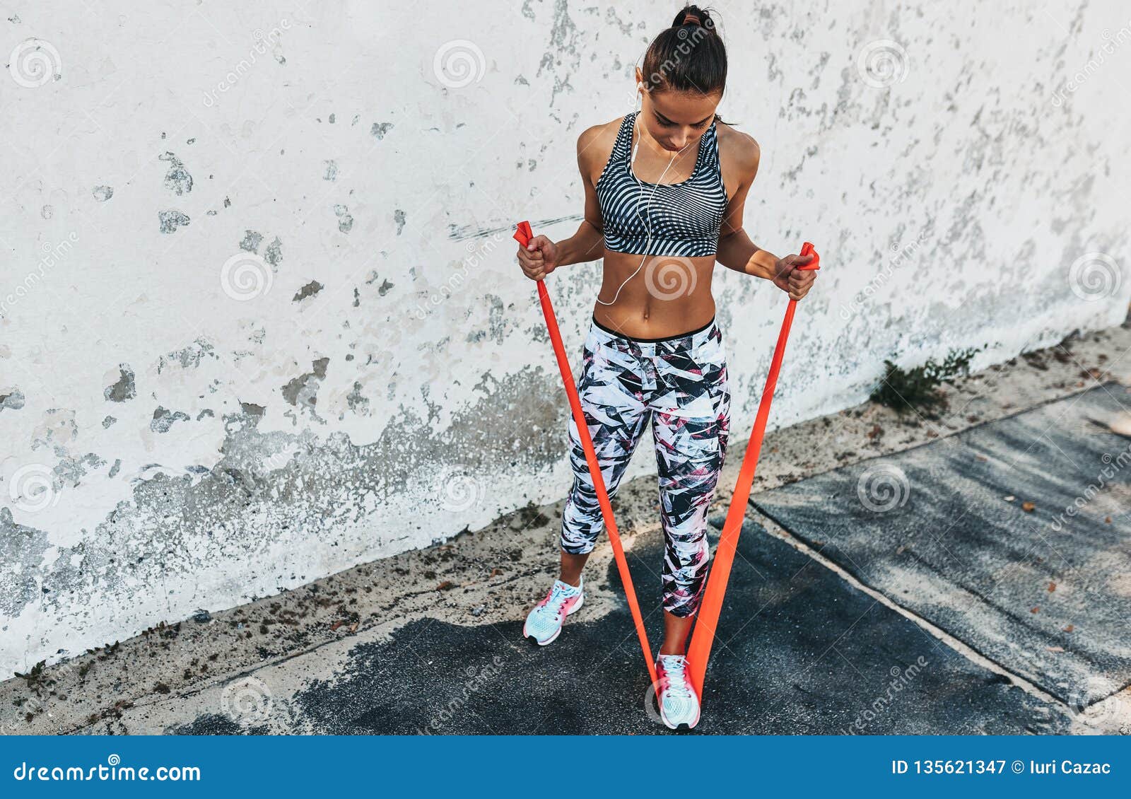 Overhead View Of Fitness Woman Standing Against Concrete Wall Doing