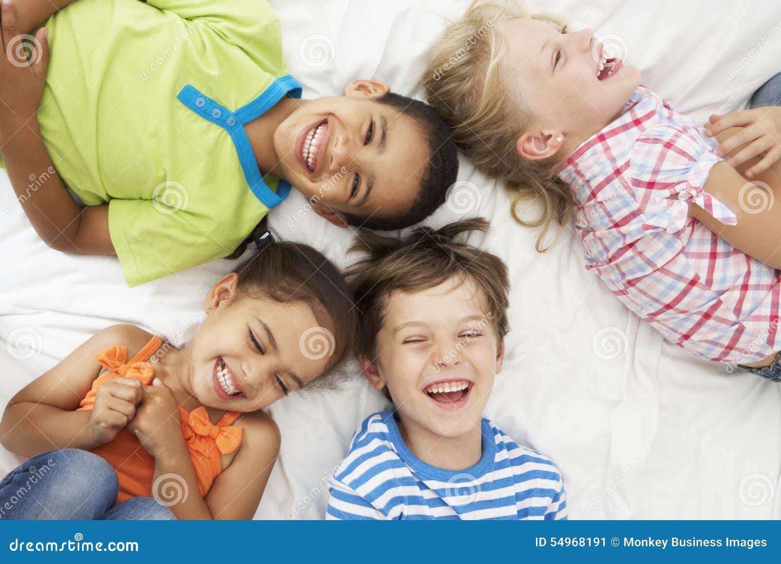 Overhead View of Four Children Playing on Bed Together Stock Image ...