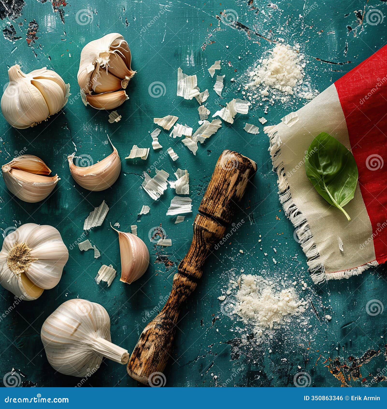 Overhead View of Garlic Cloves, Pestle, Flour, and Basil Leaf on Teal ...