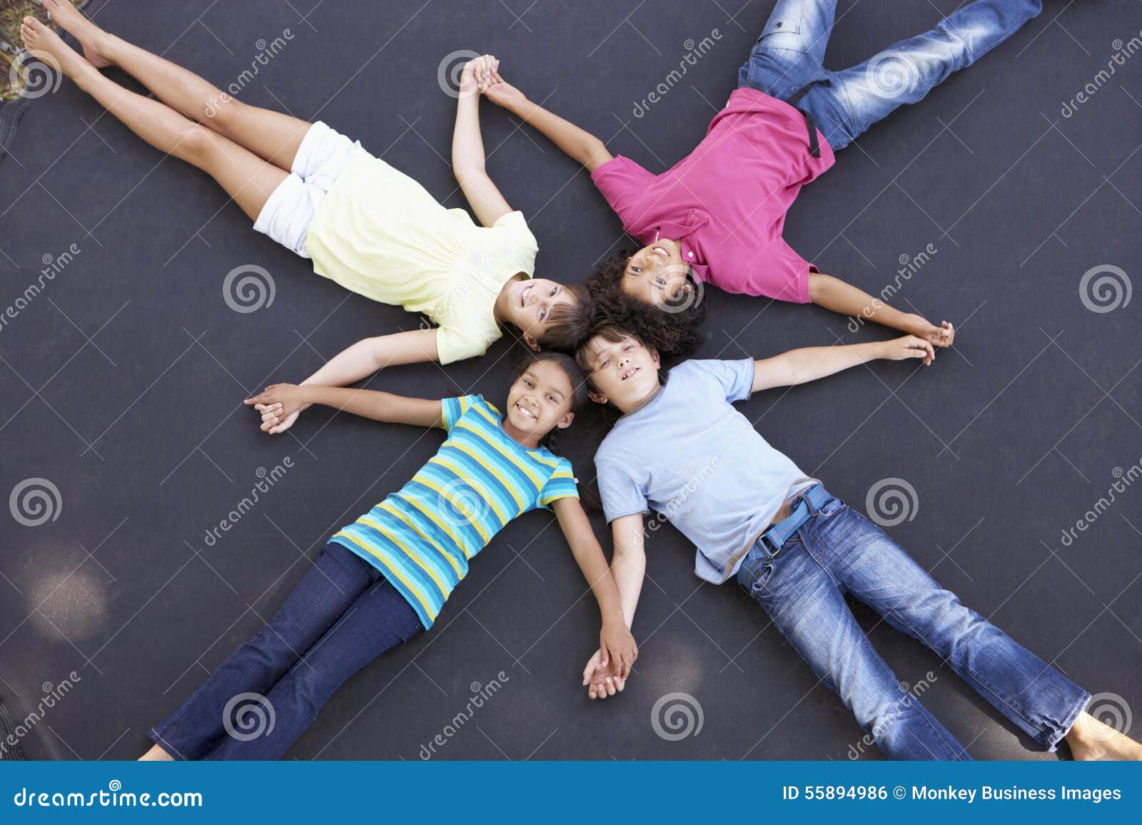 Overhead View of Group of Children Lying on Trampoline Together Stock ...