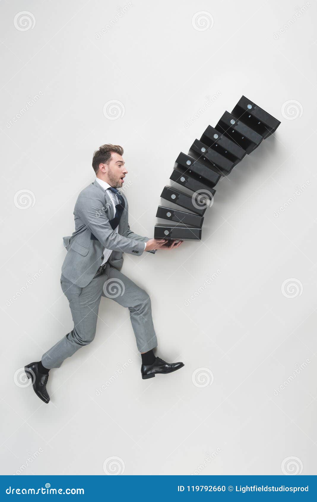 Overhead View of Young Businessman Carrying Stack of Falling Folders ...