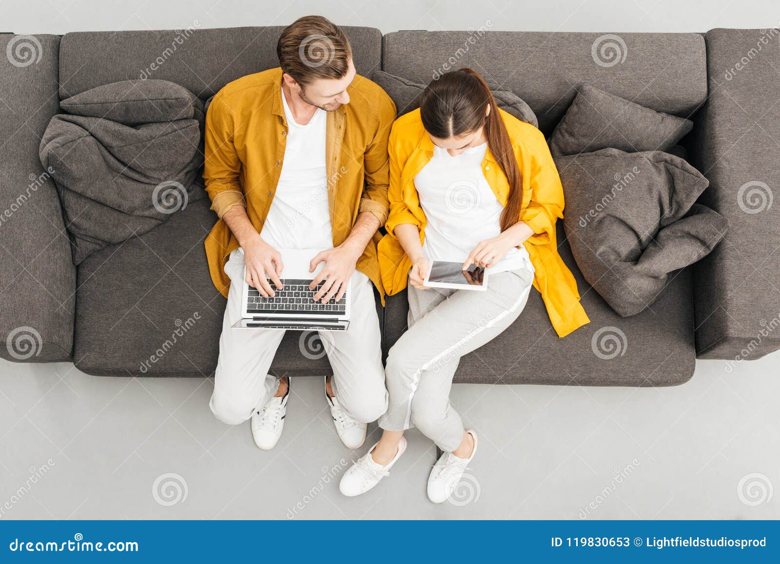 Overhead View of Young Couple Using Digital Devices on Cozy Couch Stock ...