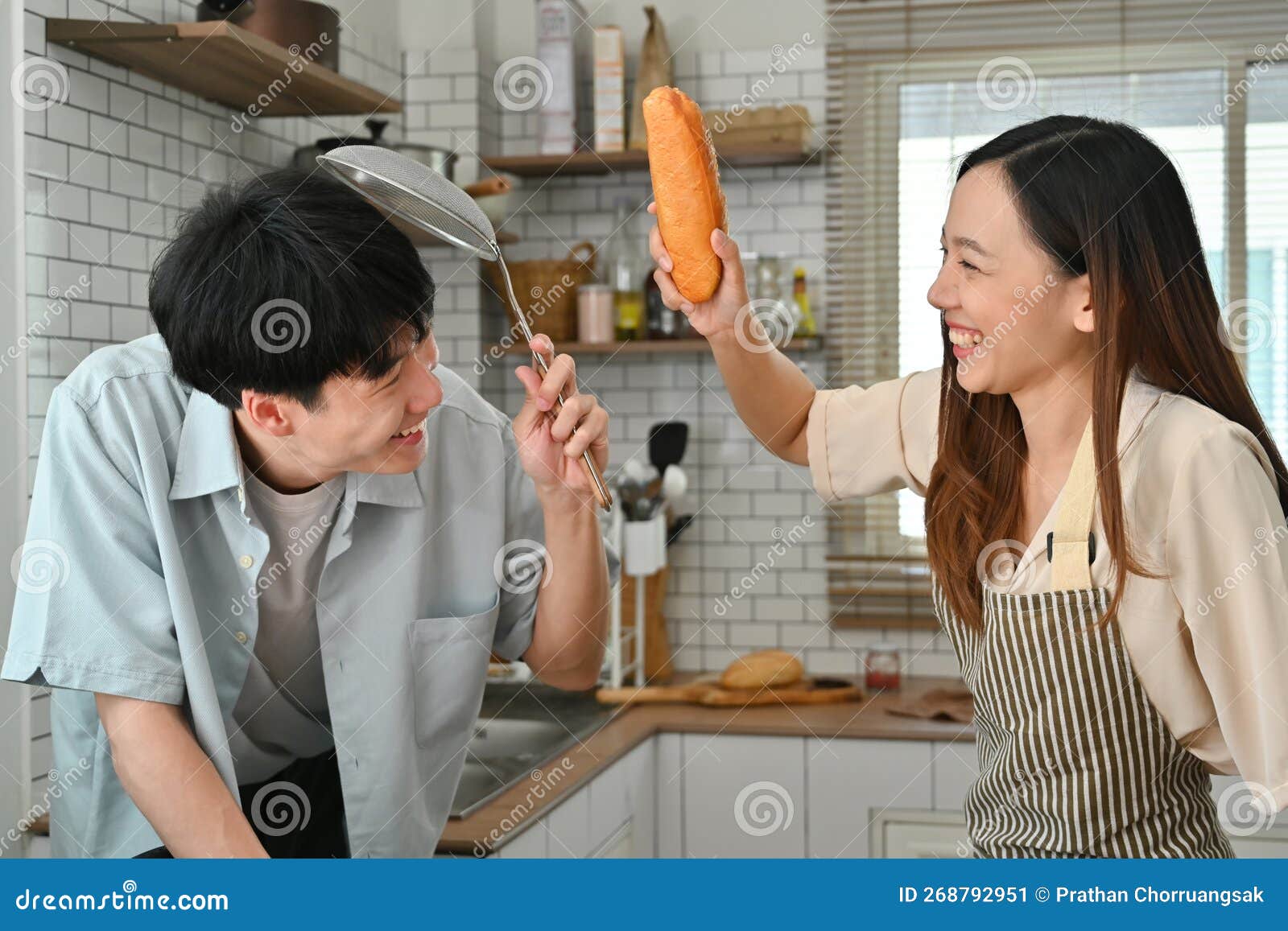 Overjoyed Married Couple Using Kitchenware and Bread Baguettes Fighting ...