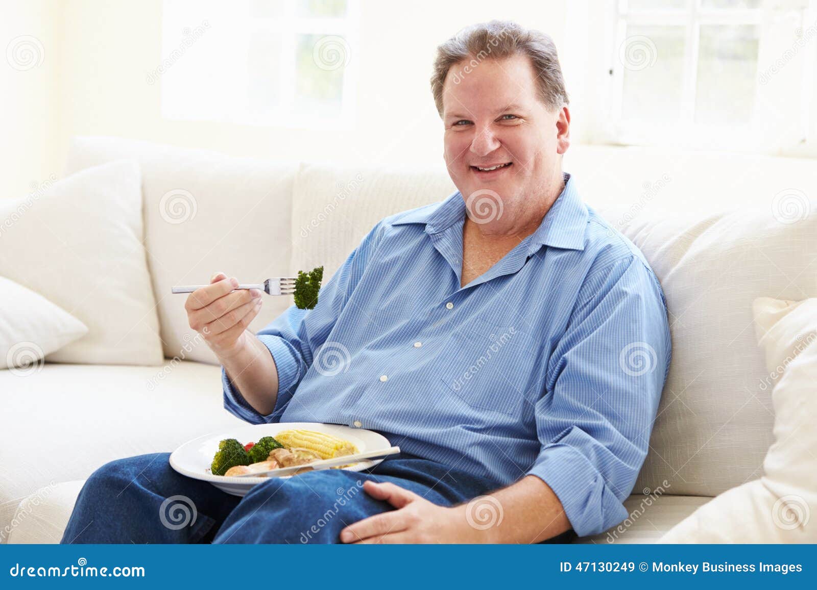 Overweight Man Eating Healthy Meal Sitting on Sofa Stock Image - Image ...