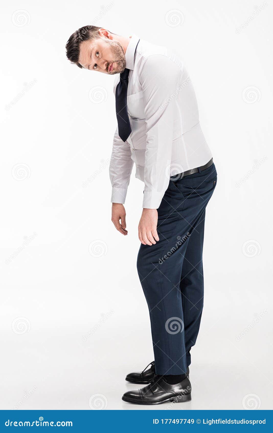 Man in Tight Formal Wear Looking at Camera and Bending Over on White ...