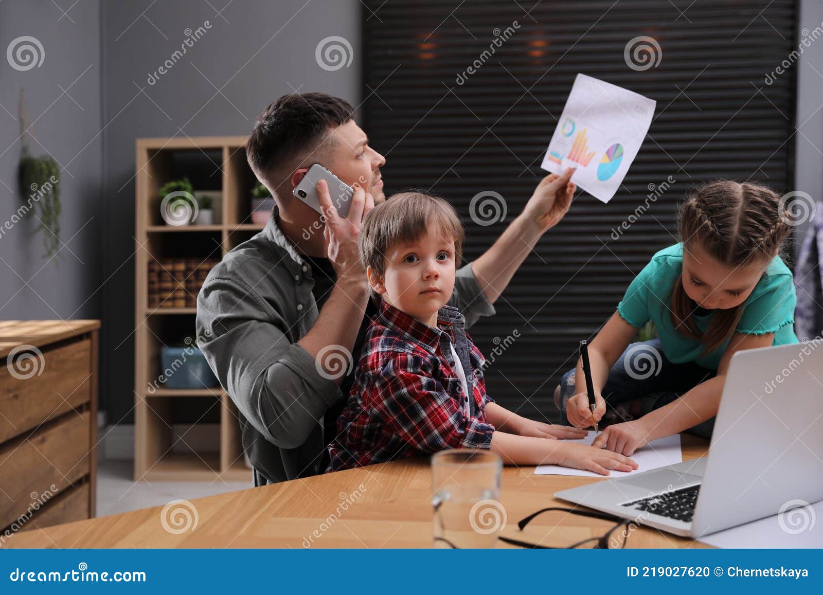 Overwhelmed Man Combining Parenting and Work at Home Stock Photo ...