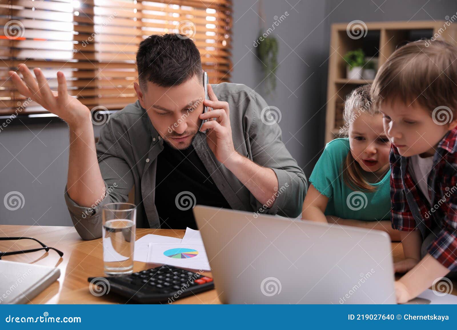 Overwhelmed Man Combining Parenting and Work at Home Stock Photo ...