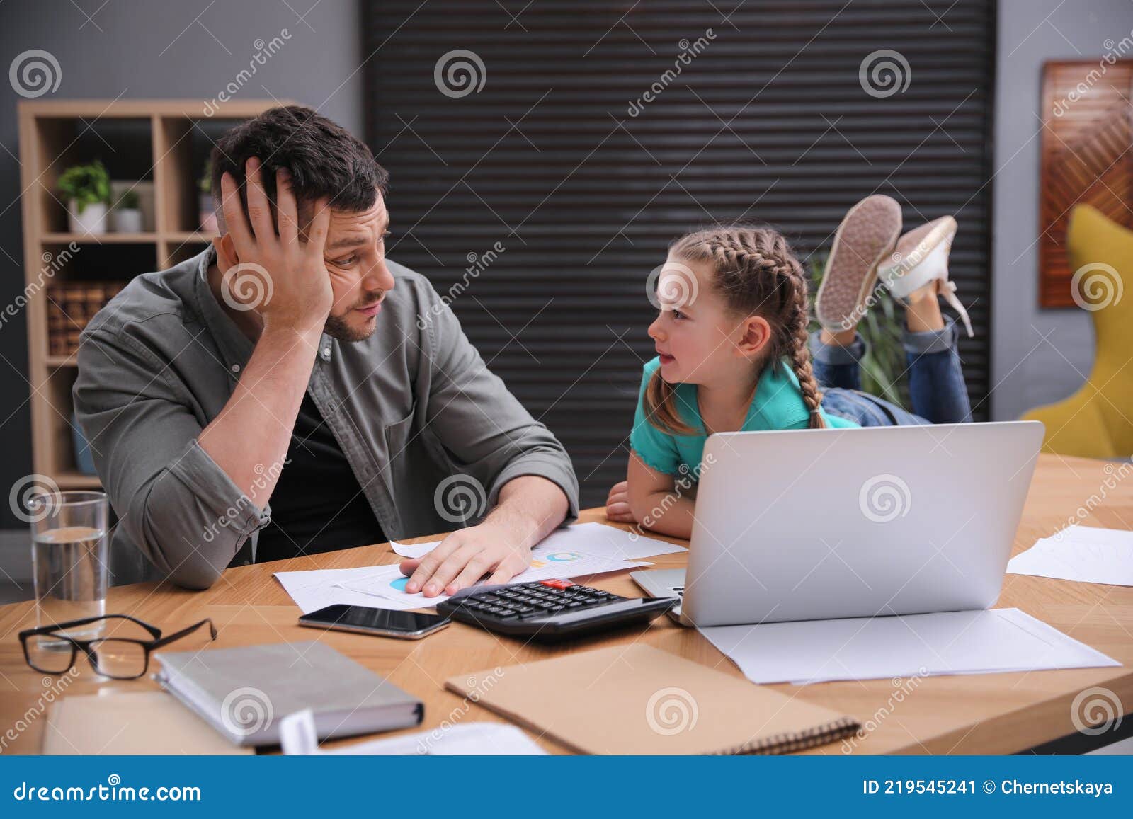 Overwhelmed Man Combining Parenting and Work at Home Stock Image ...