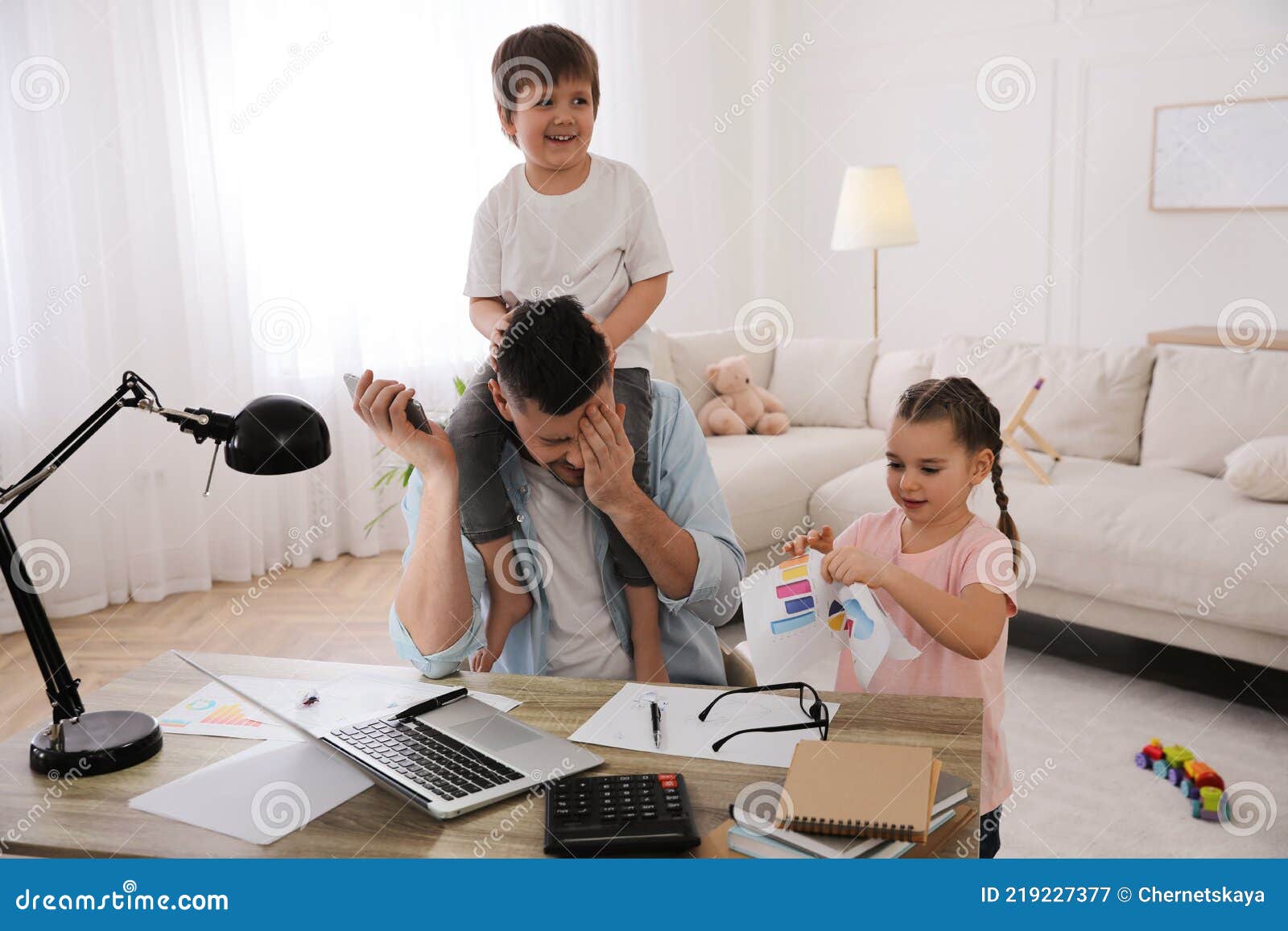 Overwhelmed Man Combining Parenting and Work at Home Stock Image ...