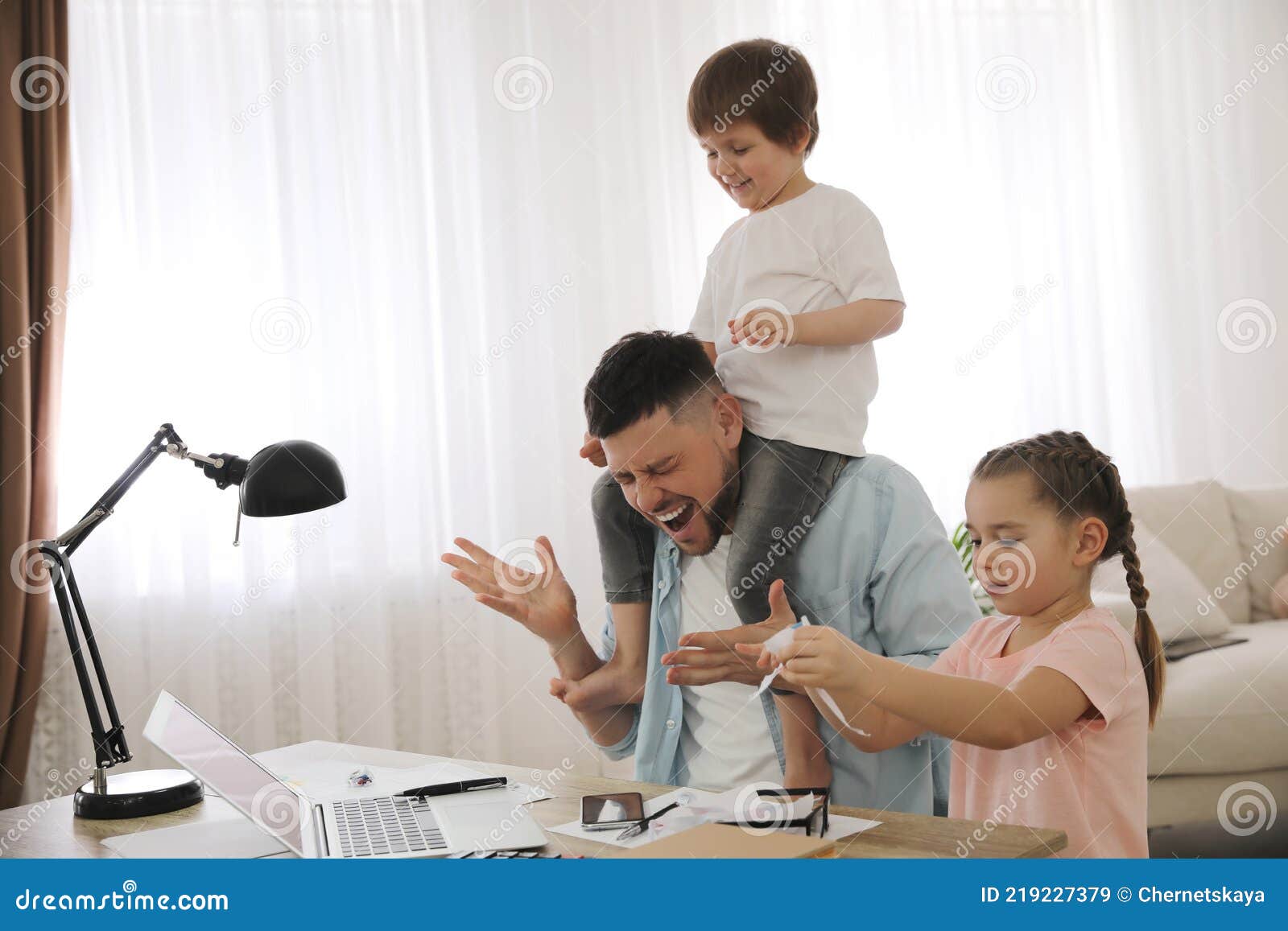 Overwhelmed Man Combining Parenting and Work at Home Stock Image ...
