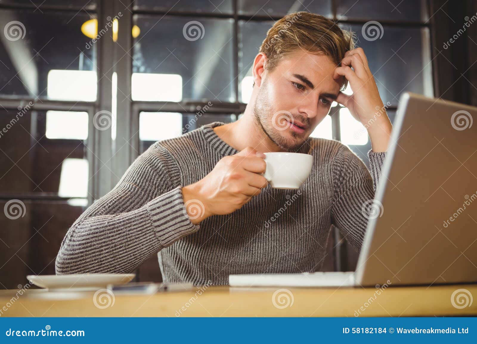 Overworked Man Drinking Coffee and Looking at Laptop Stock Photo ...
