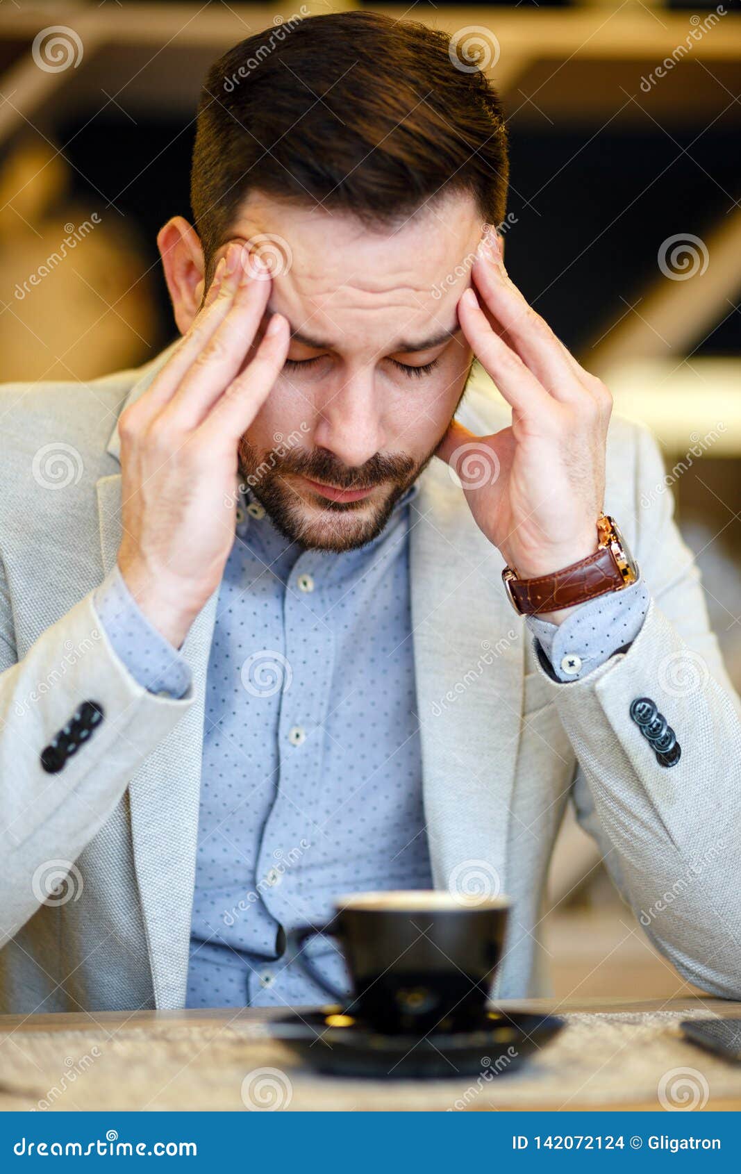 Overworked Young Businessman Having a Headache and Concentrating while ... Overworked Young Businessman Having a Headache and Concentrating while ...