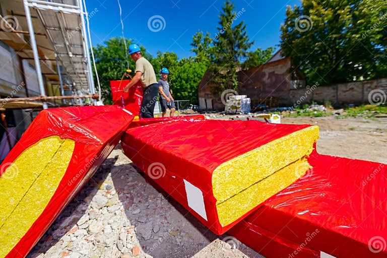 Packages with Stone Wool Arranged in a Pile, the Workman is Hanging the ...