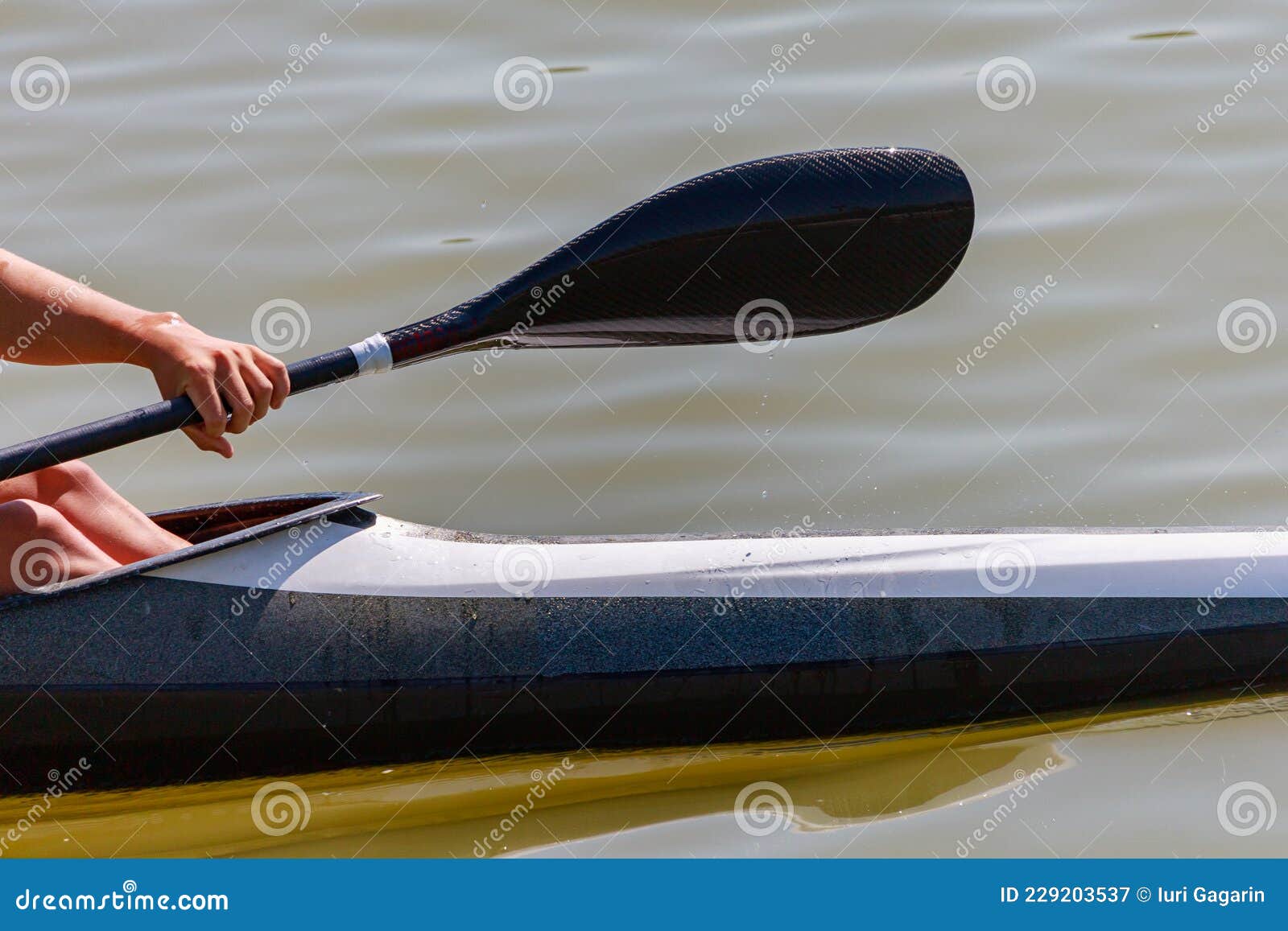 Paddle in the Hand of a Man in a Kayak on the River. Background with ...