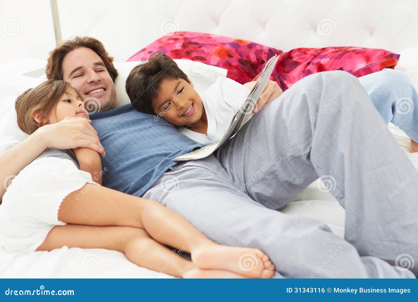 Padre and Children Relaxing En Cama Junto Foto de archivo - Imagen de ...