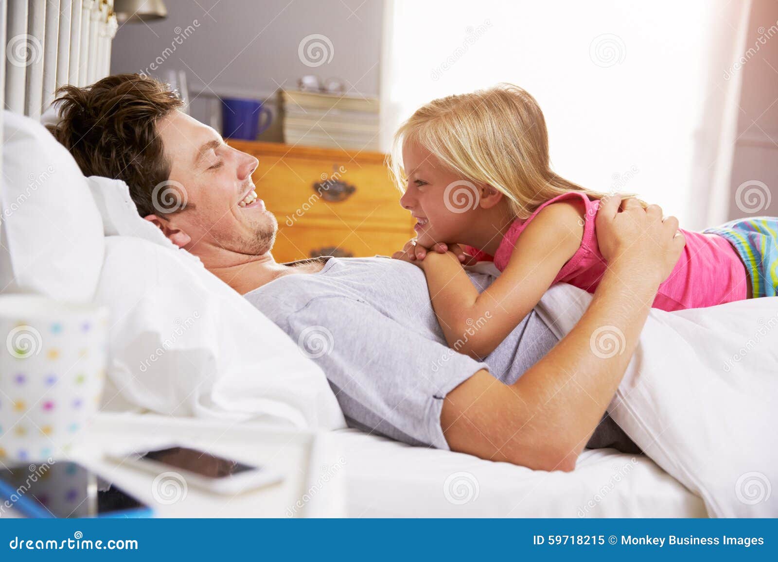 Padre and Daughter Lying En Cama Junto Imagen de archivo - Imagen de ...