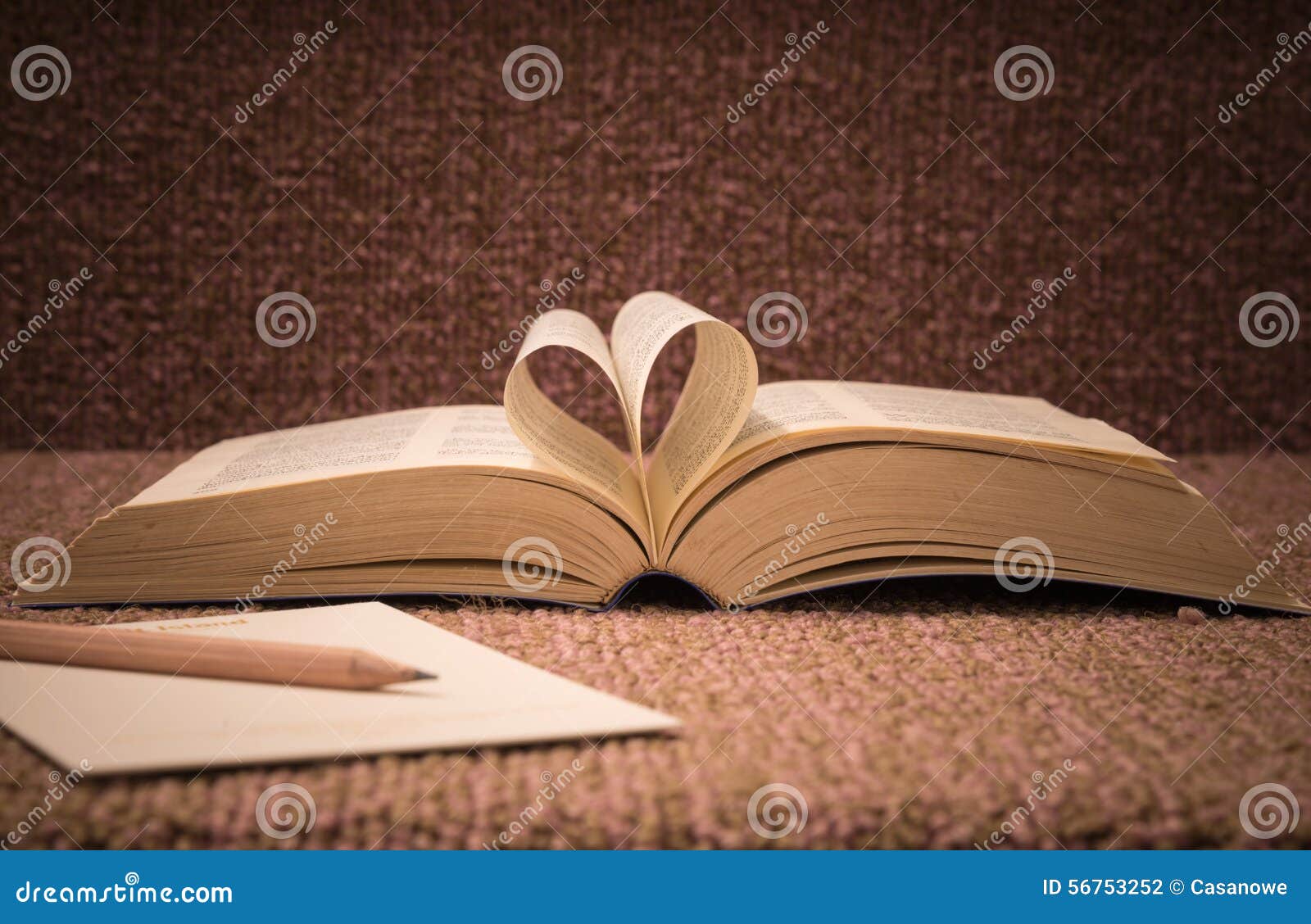 Pages of Open Book Rolled in Heart Shape on Table Stock Photo - Image ...