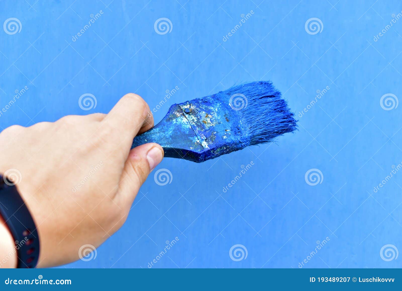 Paint Brush in Hand on a Blue Background Stock Image - Image of ...
