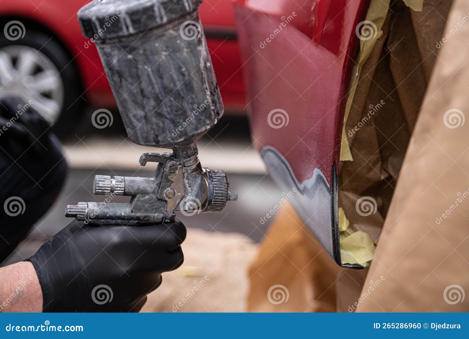 Painter Paints with Primer Paint Damage on the Bumper of a Red Car ...