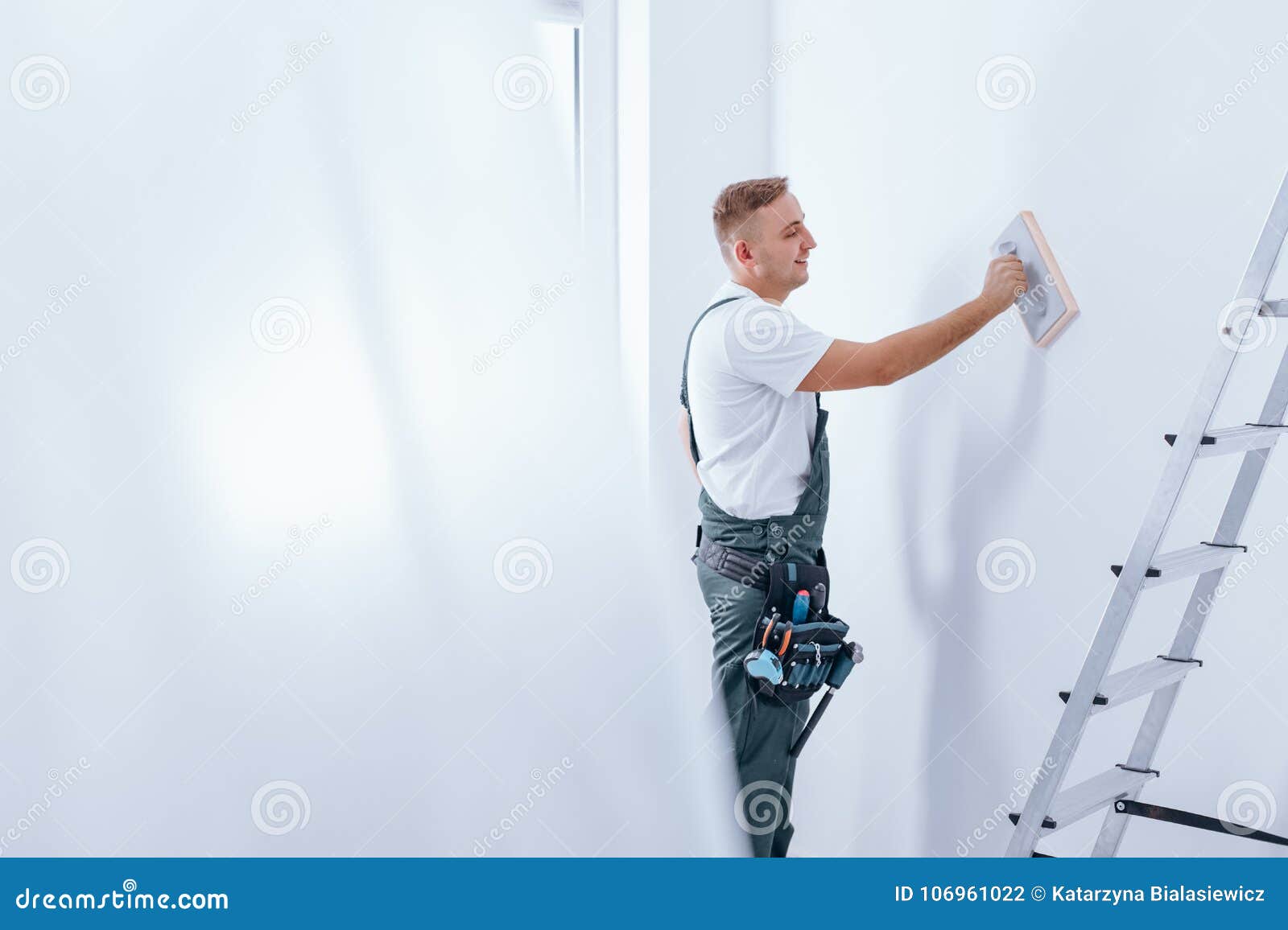 Painter smoothing the wall stock photo. Image of remodeling - 106961022