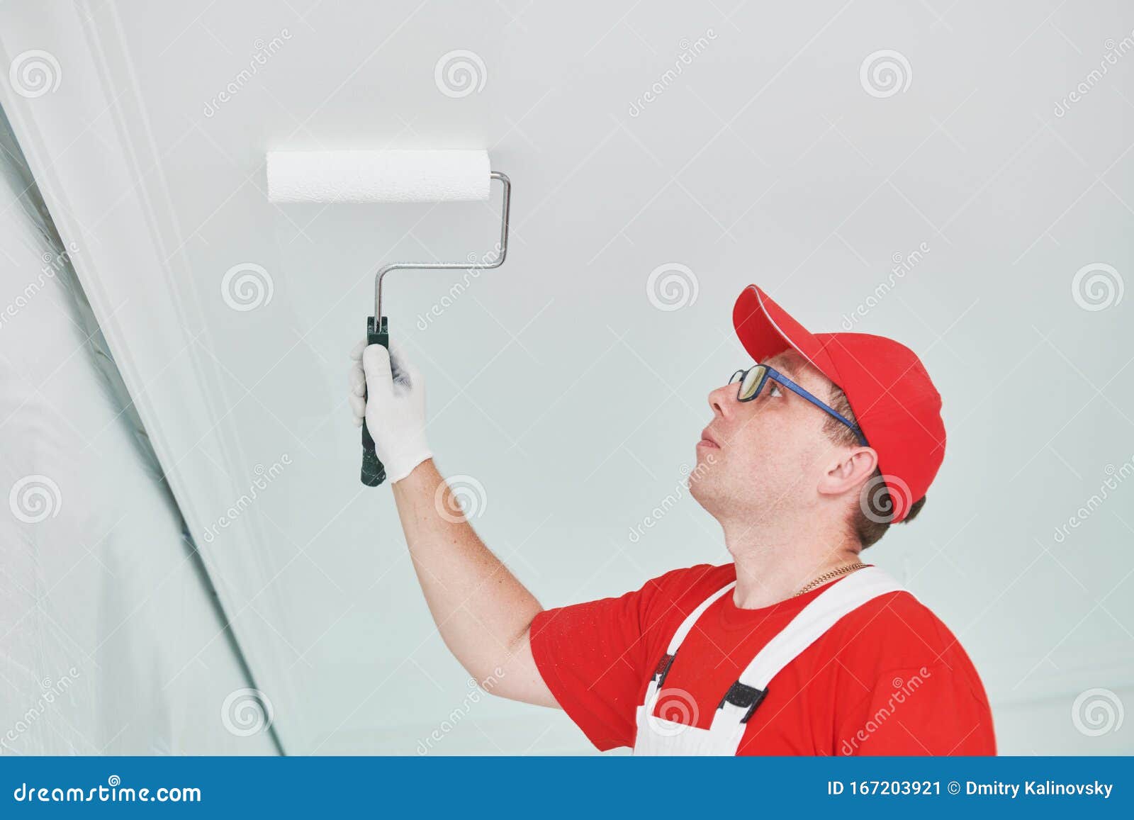 Painter Worker with Roller Painting Ceiling Surface into White Stock ...