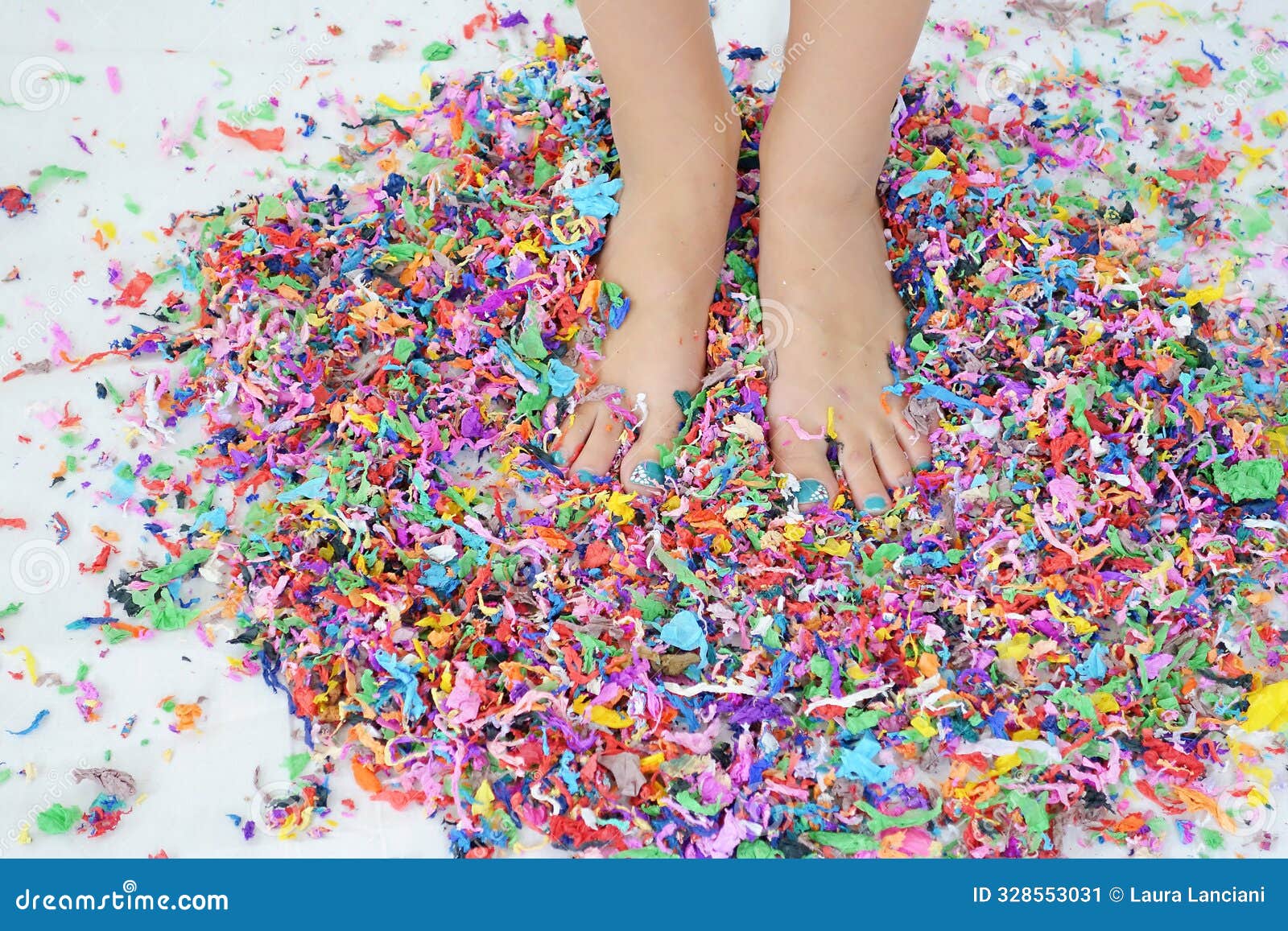 A Pair of Feet Standing in a Pile of Brightly Colored Confetti Stock ...