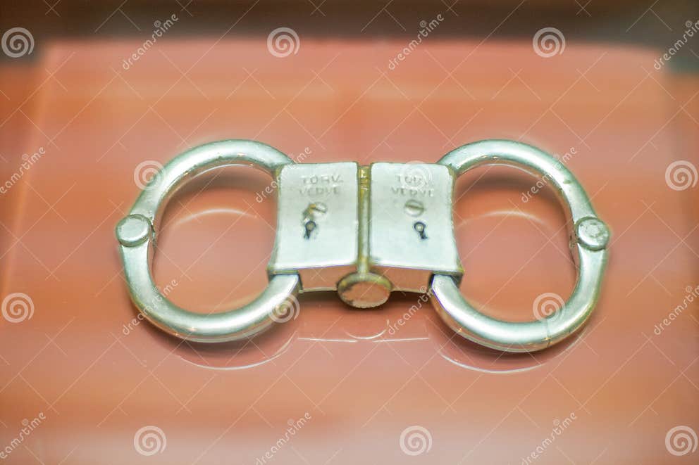 A Pair of Metallic Handcuffs are Placed on a Light-colored Surface ...