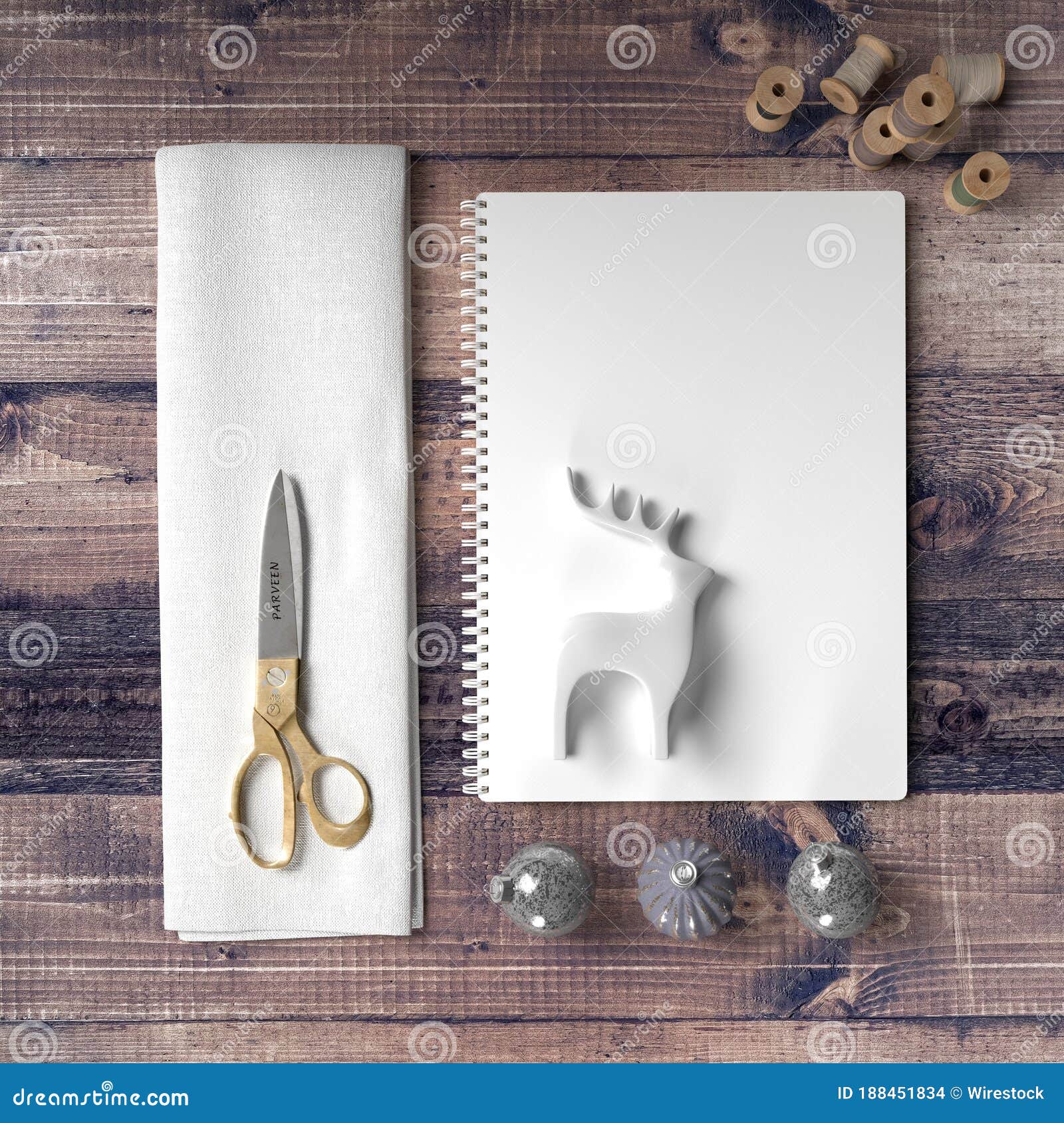 Pair of Scissors and a Small Statue of a Reindeer Put on White Surfaces ...