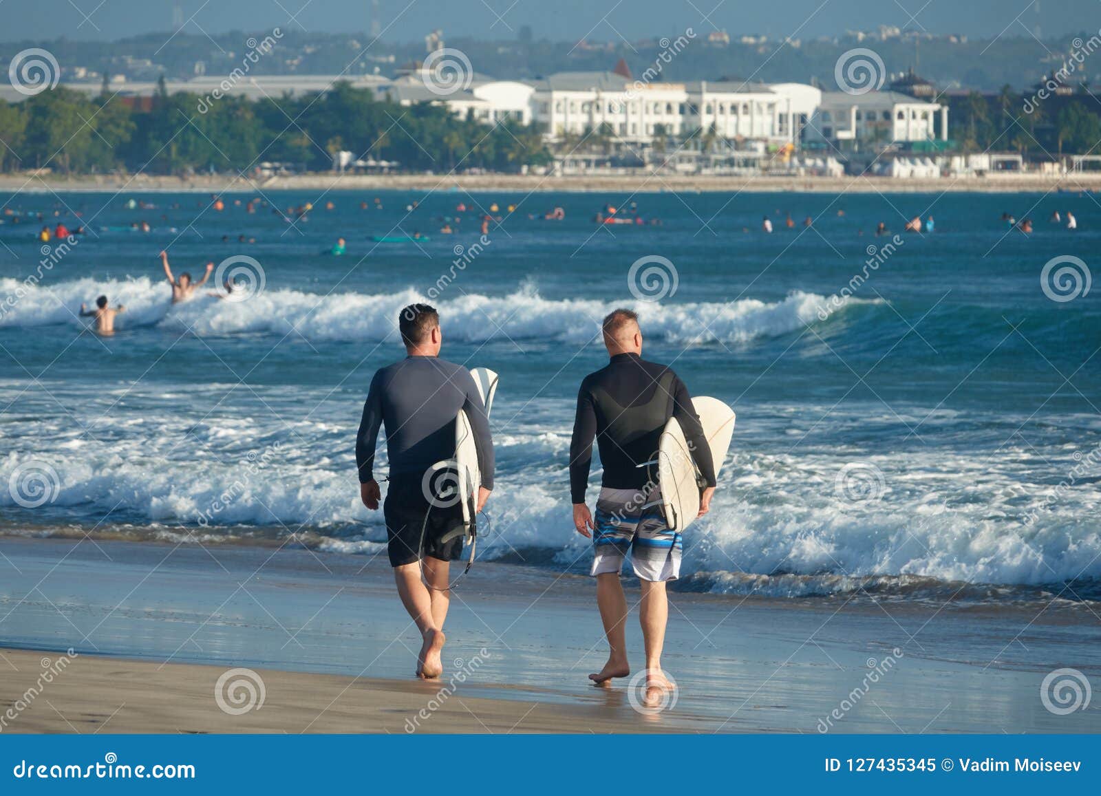 A Pair of Surfers Walk with Surfboards on a Beach Along a Sea Editorial ...
