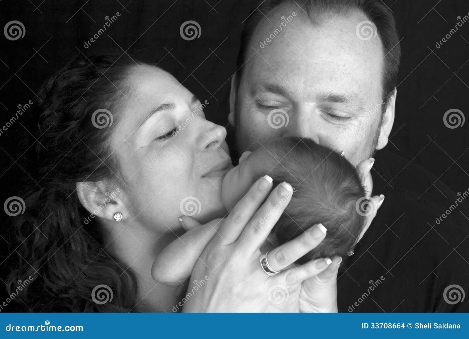 Pais que beijam o bebê foto de stock. Imagem de preto - 33708664