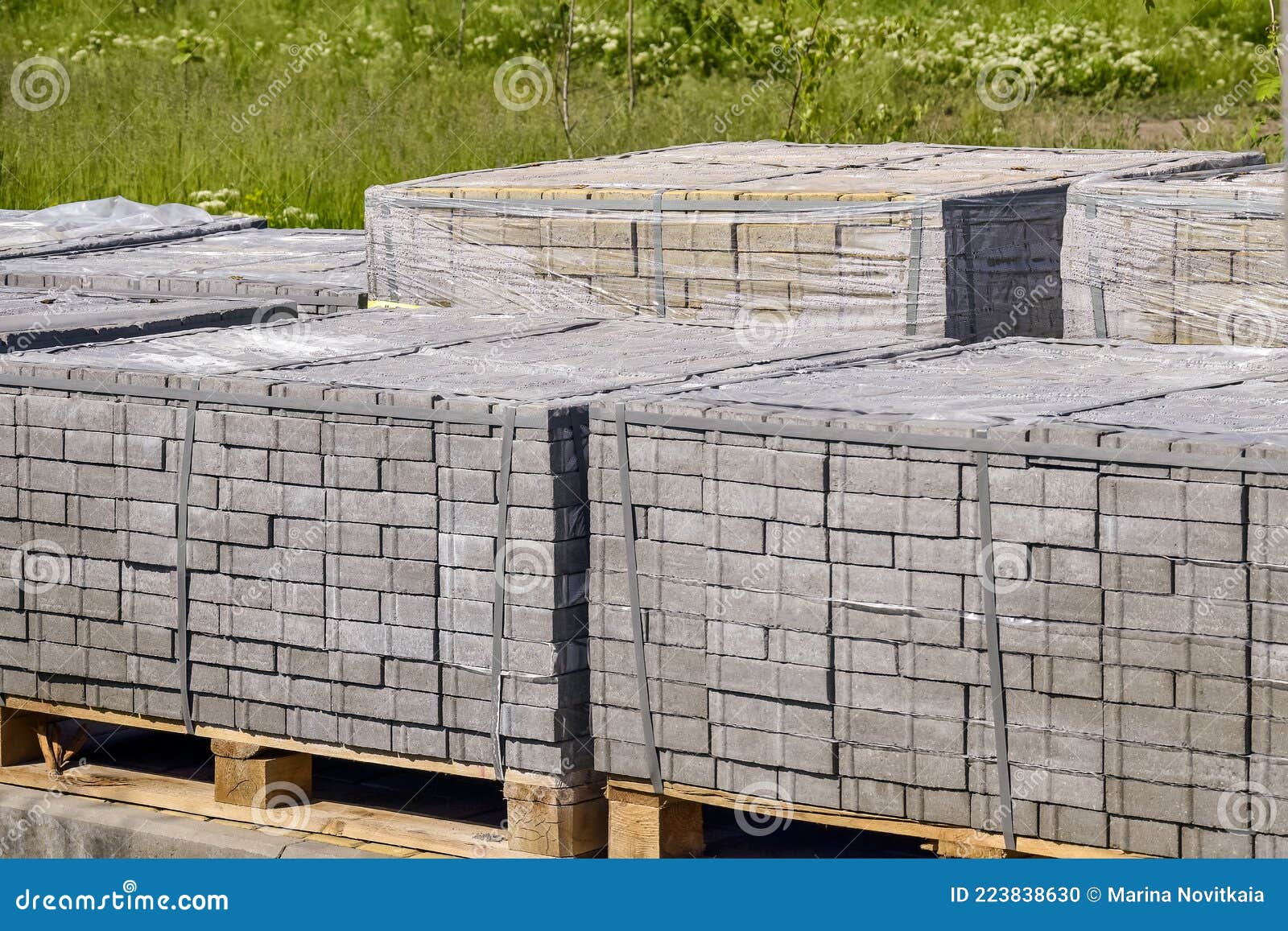 Pallets with Gray Paving Slabs on Background of Green Grass. Plastic ...
