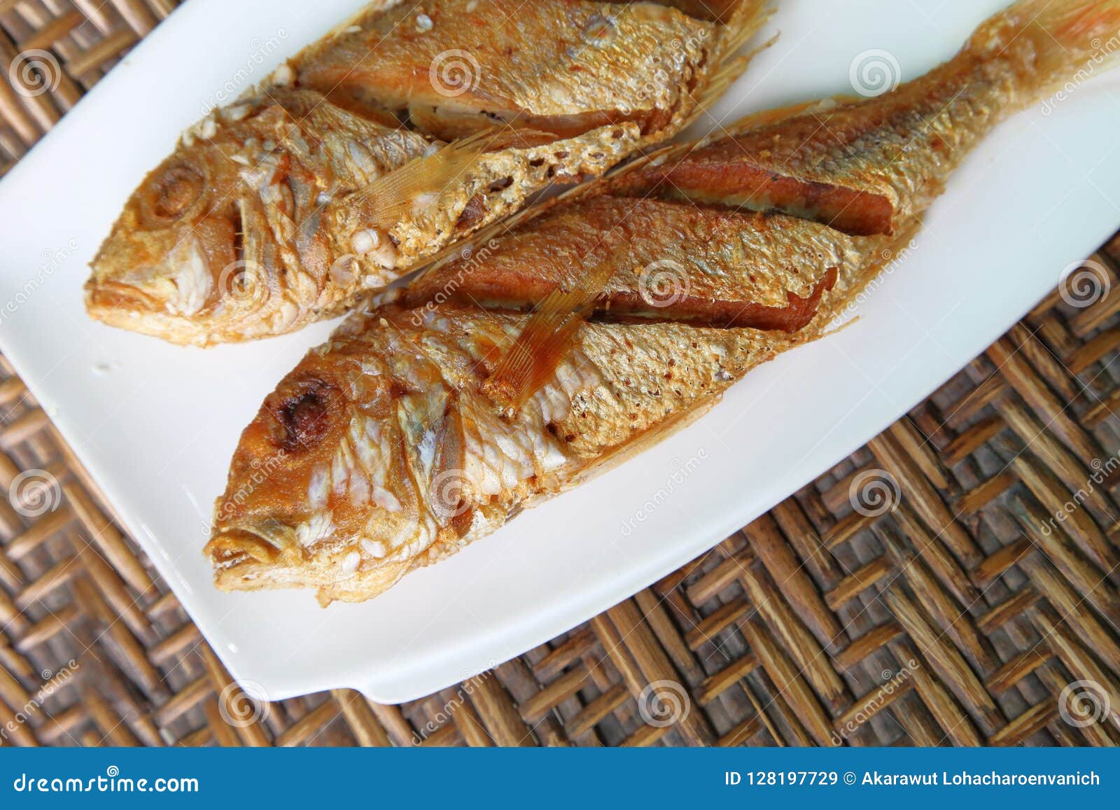 Pan Fried Fish on White Plate Over Rattan Texture Stock Image - Image ...